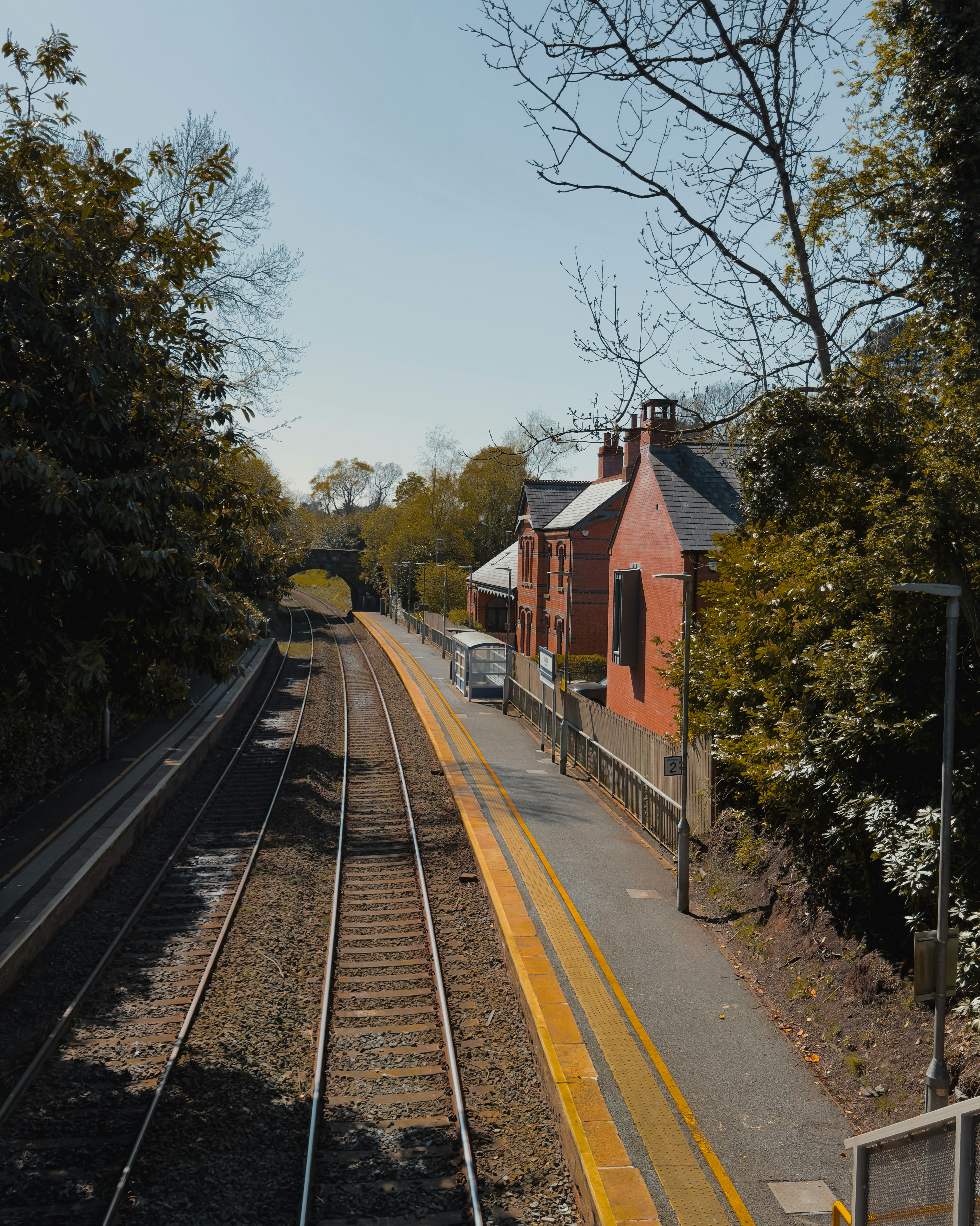 Overpass to a Quiet Station: Rails, Brick, and Autumn Light