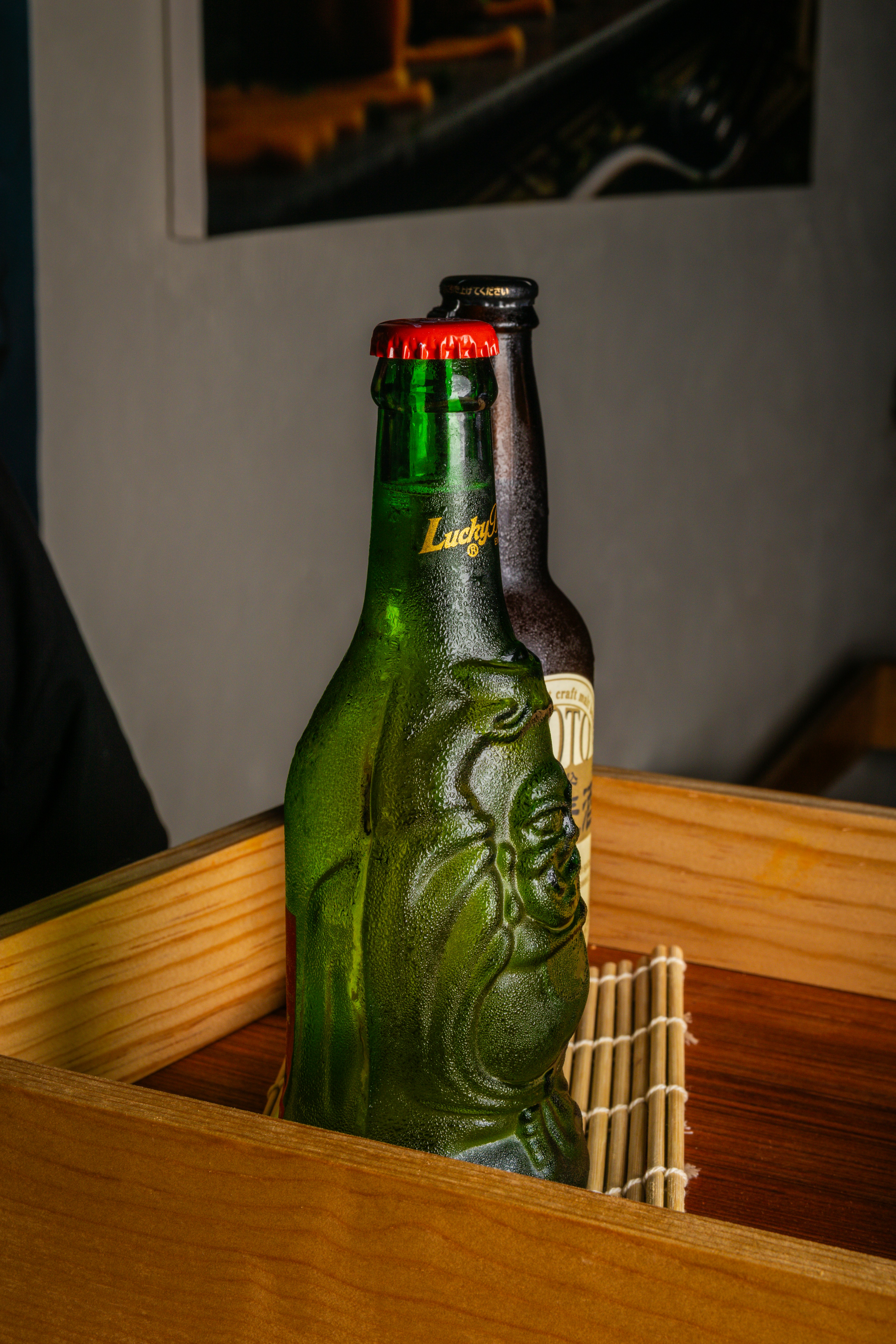 Green Glass Bottle with embossed design in a wooden bar setting
