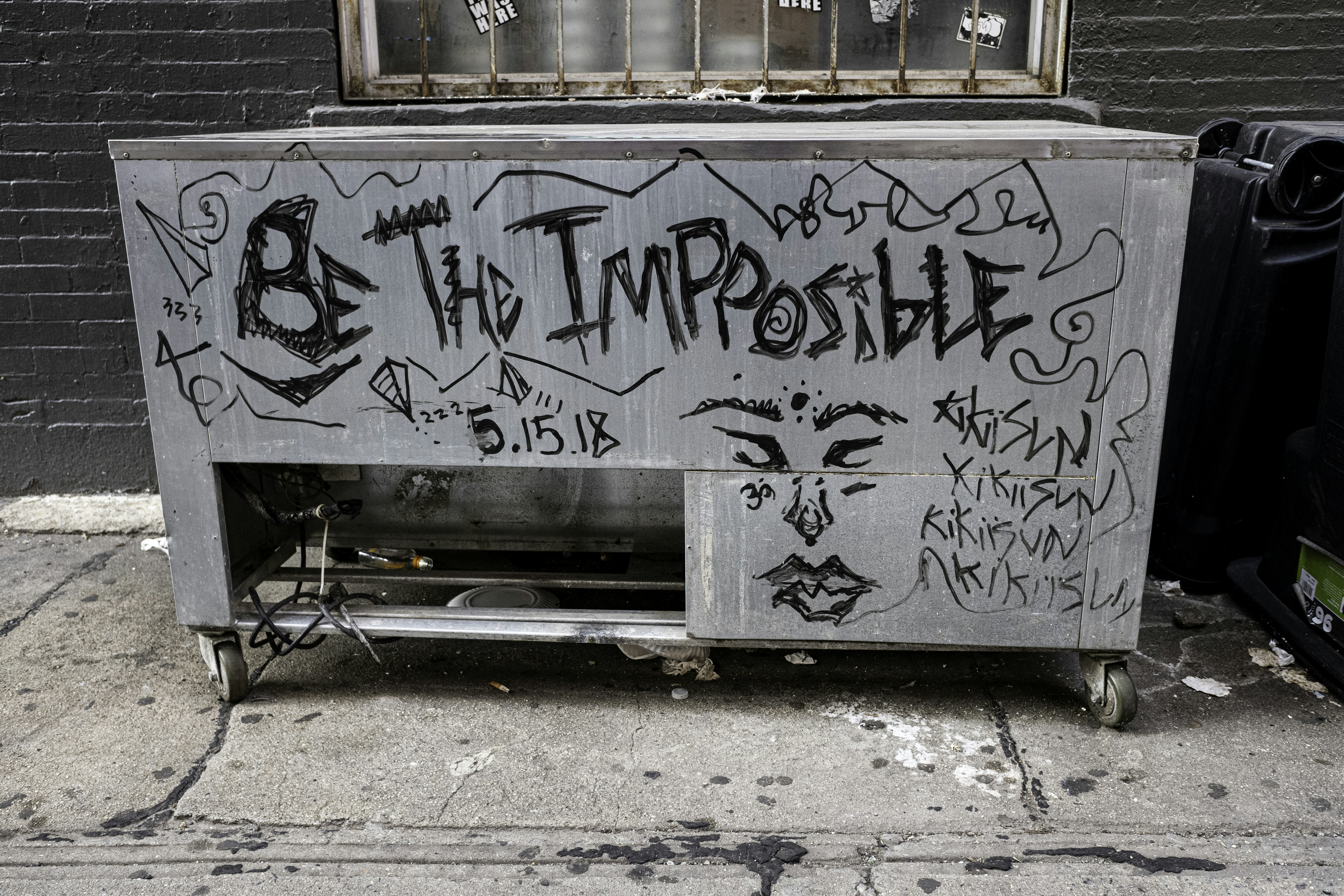 Graffiti on a City Dumpster: Faces of Steel and Stone