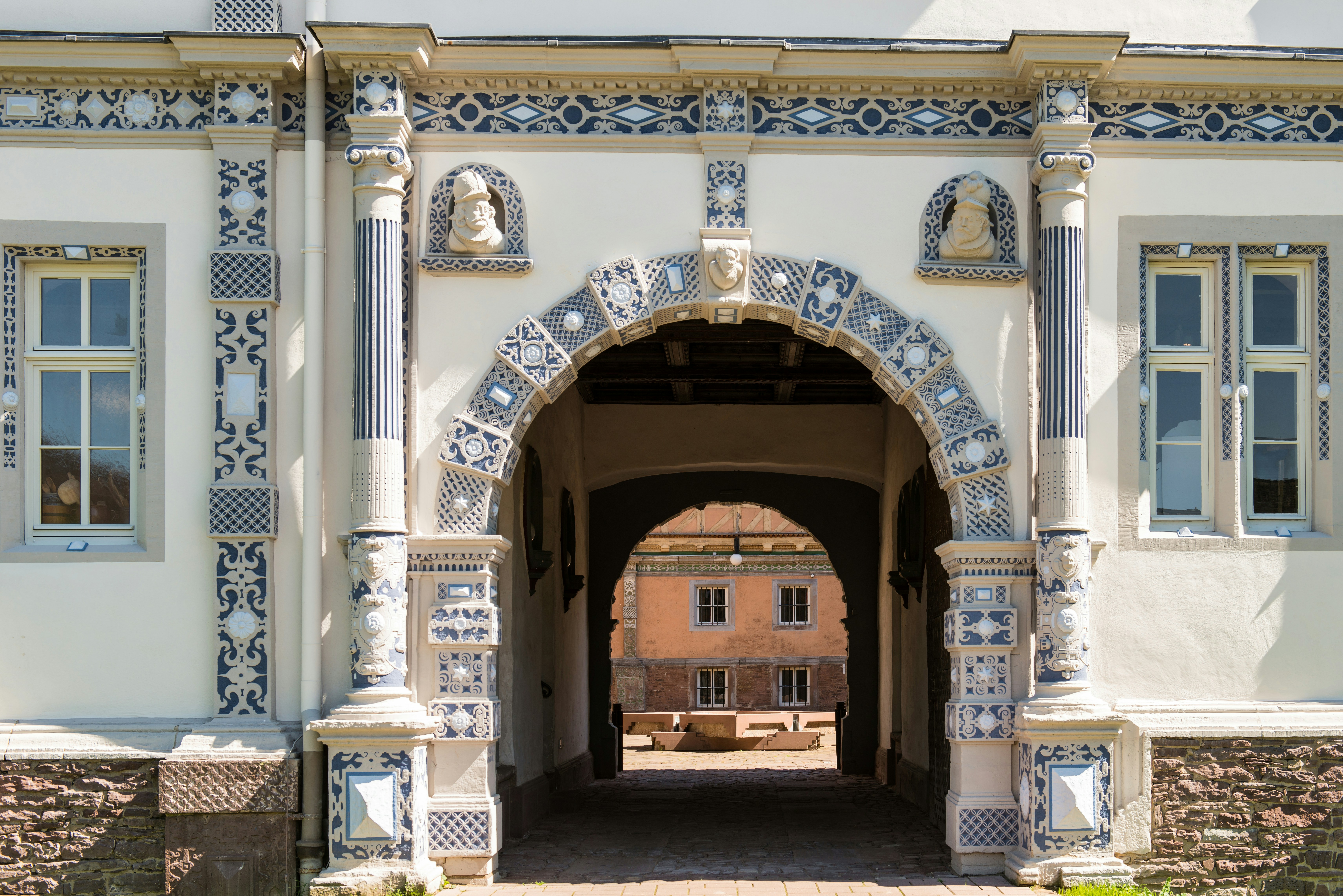 Arched Gateway Framing a Sunlit Courtyard