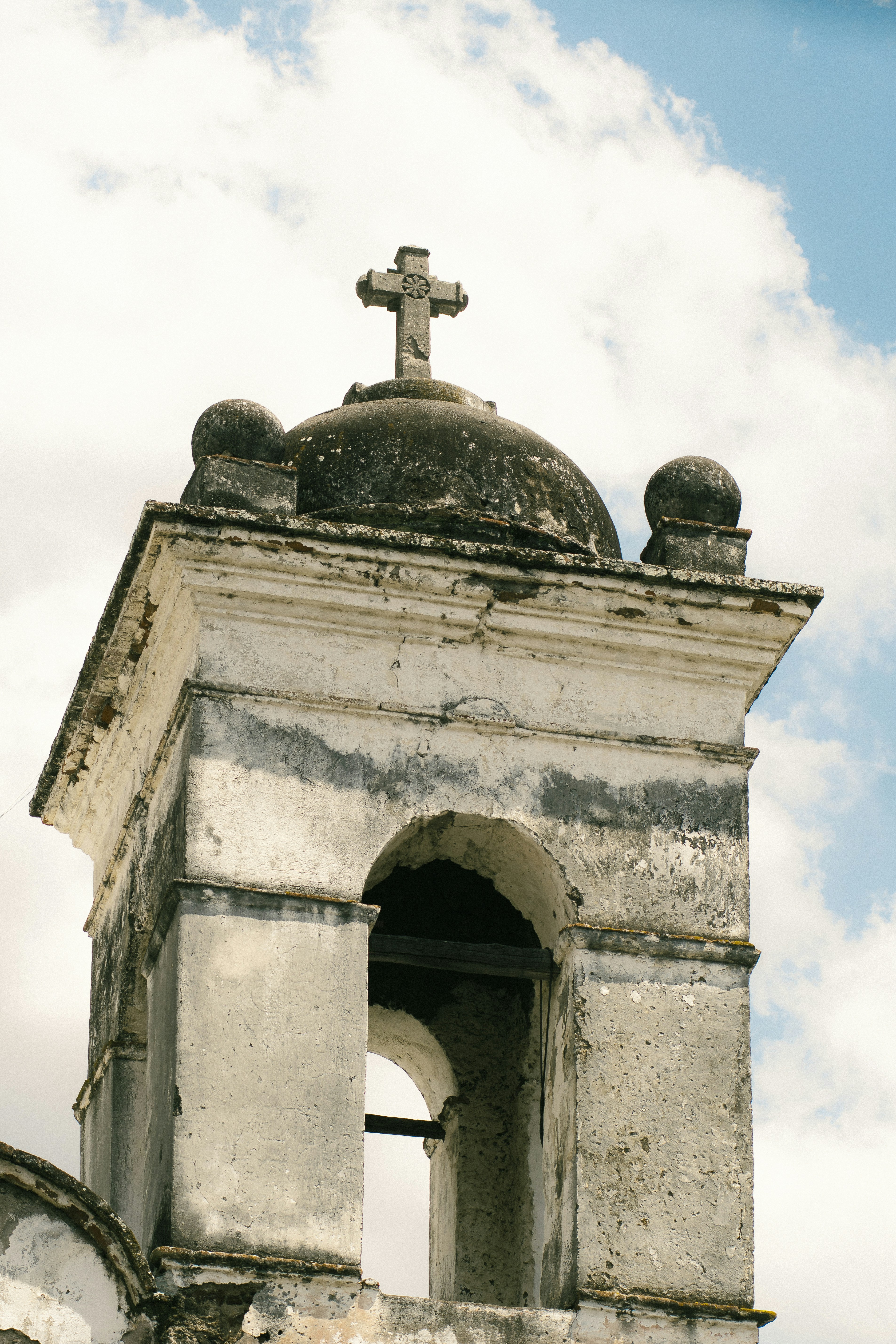 Weathered Bell Tower Reaching Toward a Clouded Sky