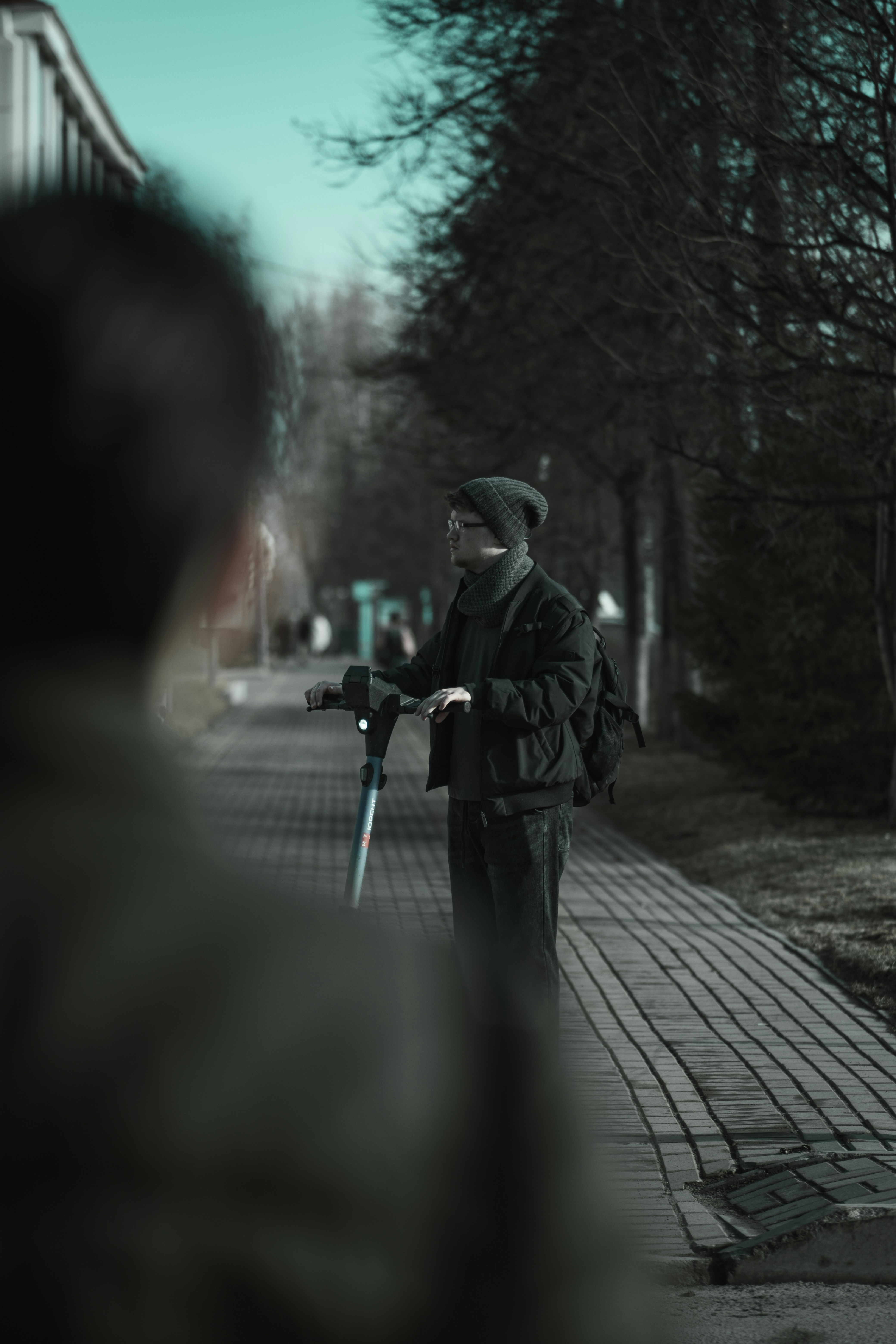 Man with Beanie and Electric Scooter On a Quiet Path