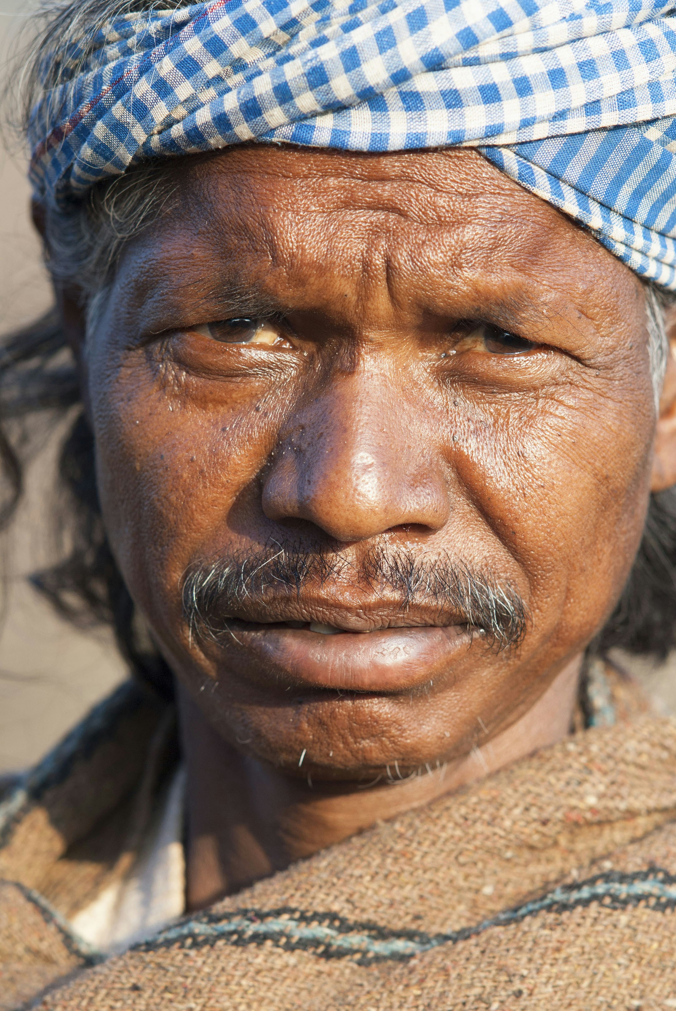 Close-Up of a Weathered Gaze Under a Blue-Check Turban