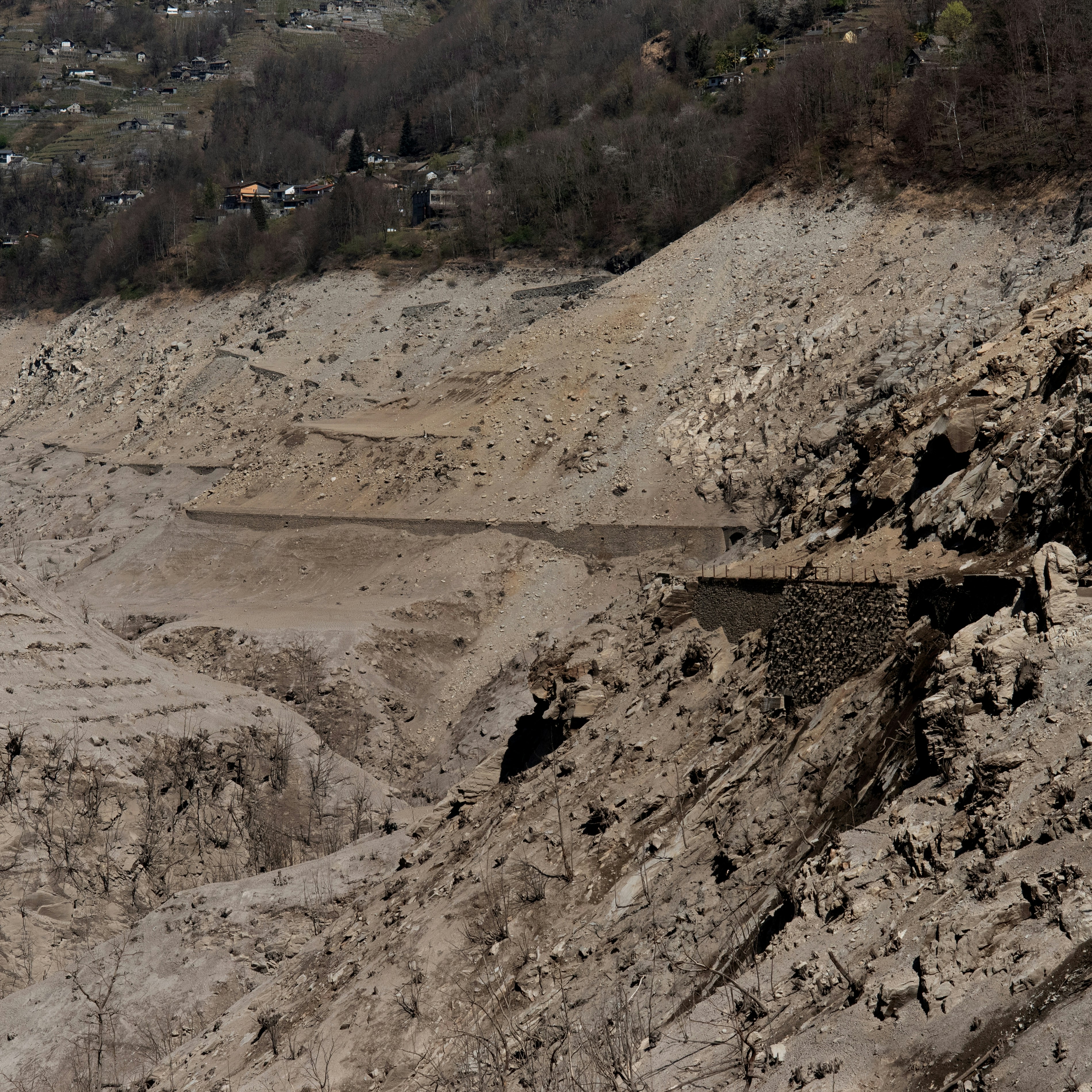 Dusty quarry terraces under a rocky slope