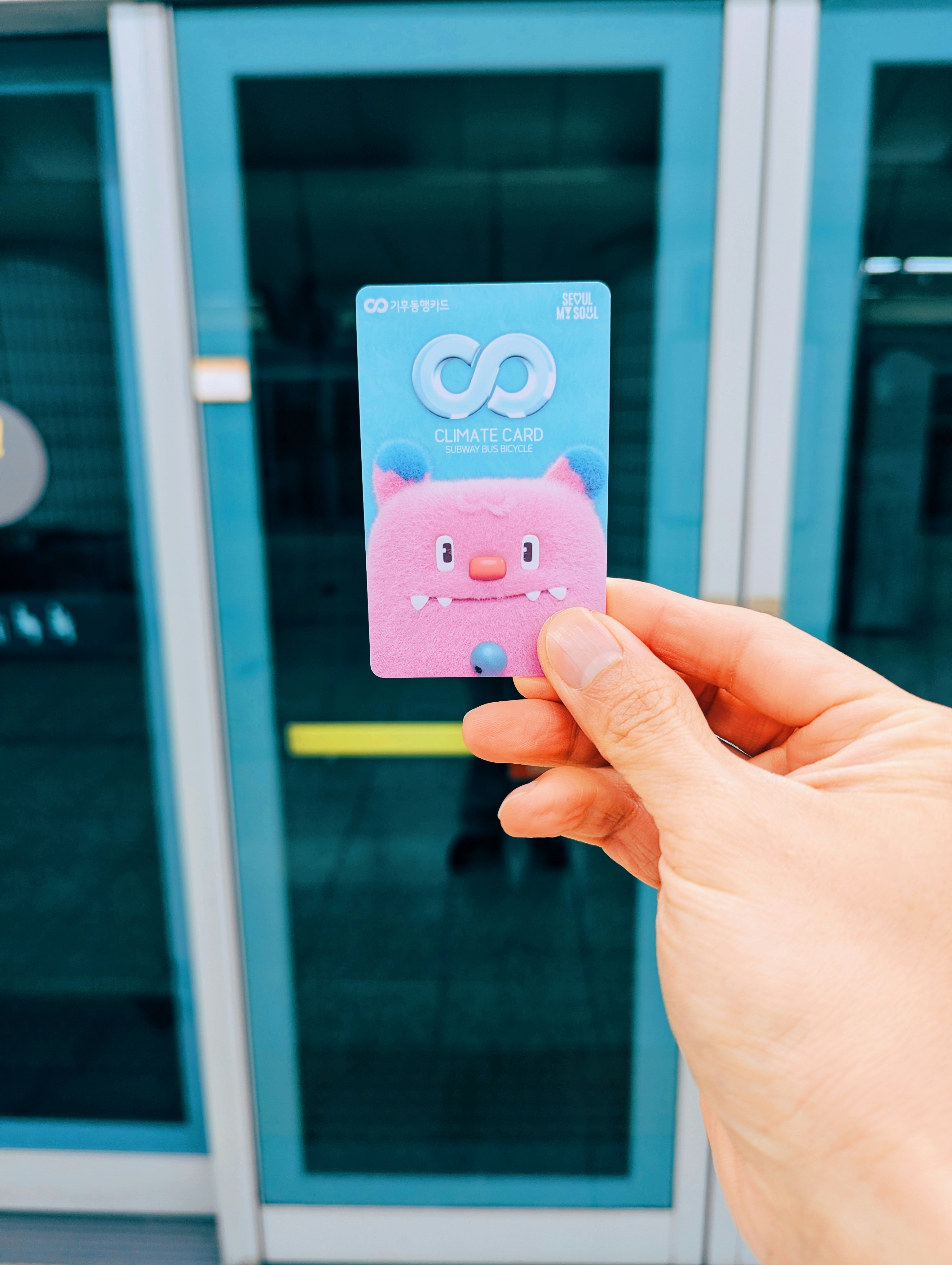Hand holding a climate card with a cute monster.
