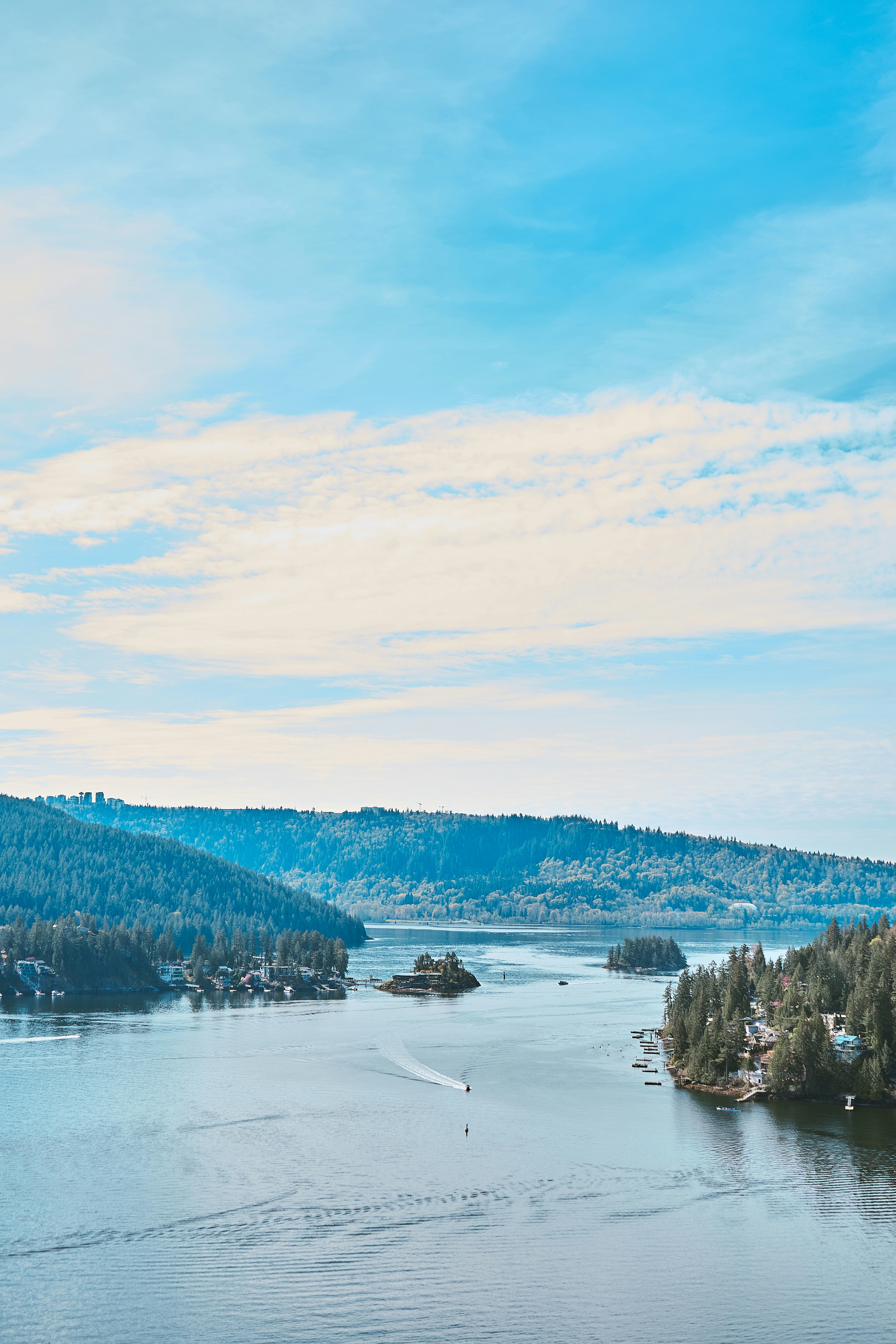 River Sweep: Framed by distant forested ridges under a pale blue sky