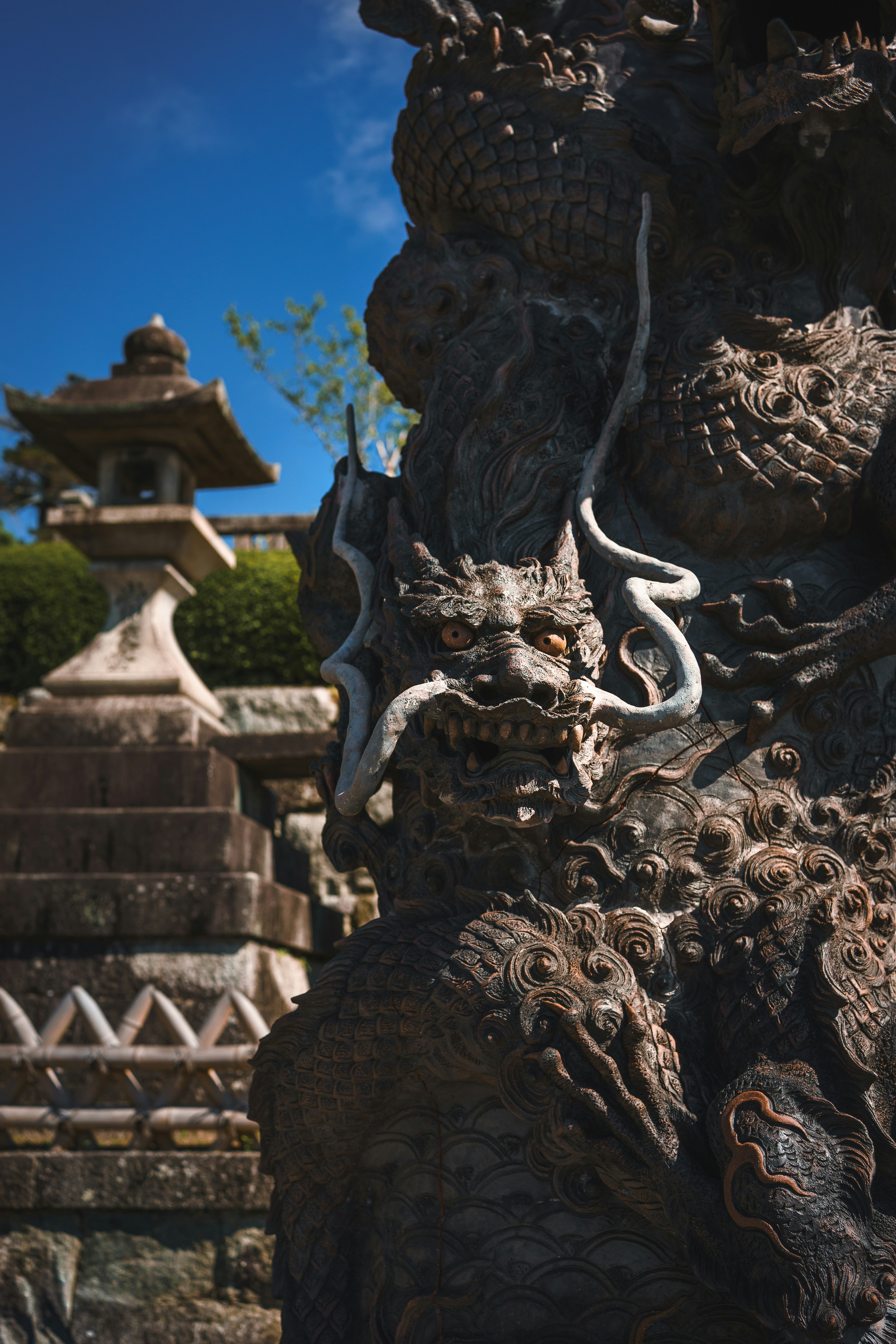 Stone Guardian: Dragon Head Foreground Under a Clear Blue Sky