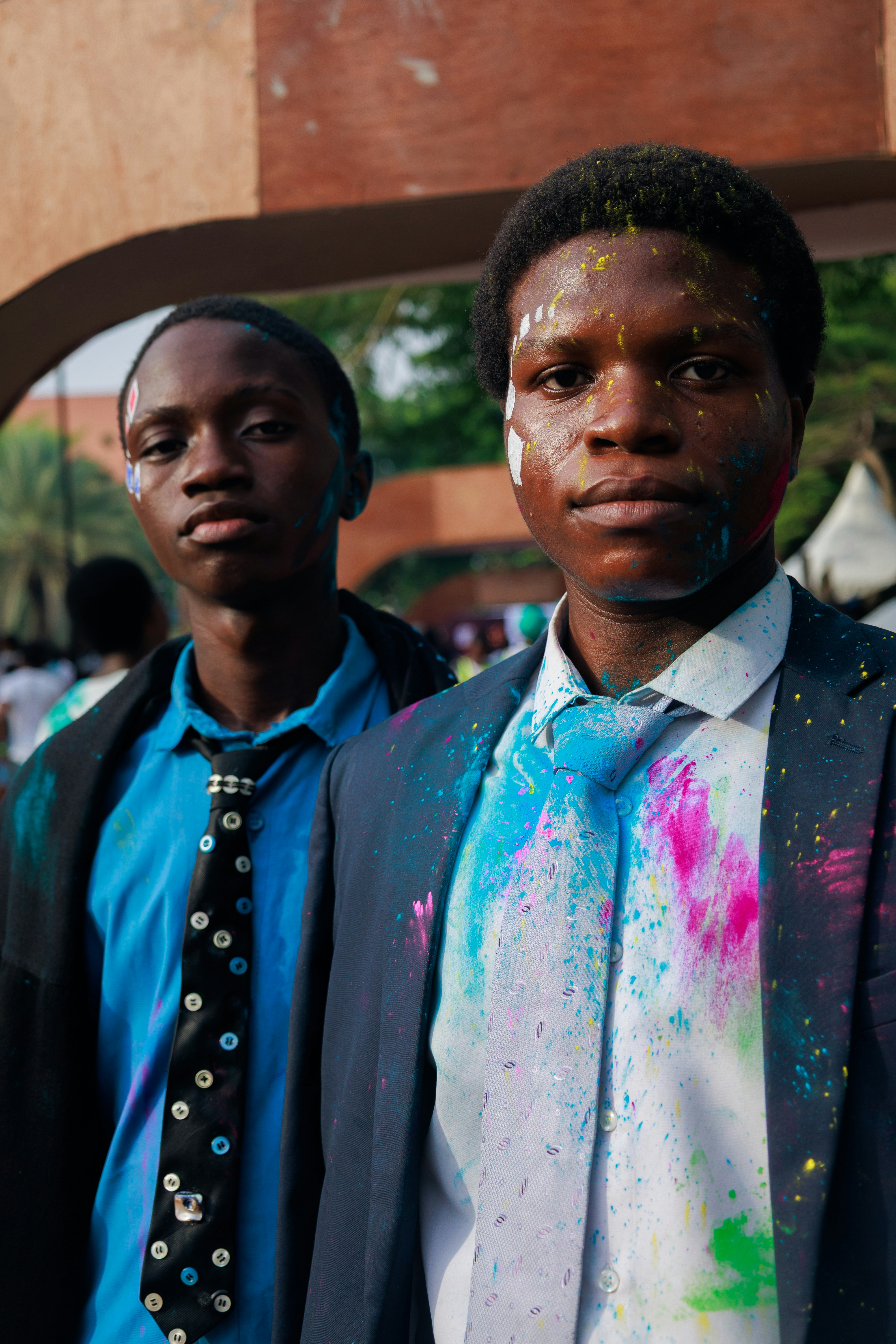 Two young men covered in colorful powder.