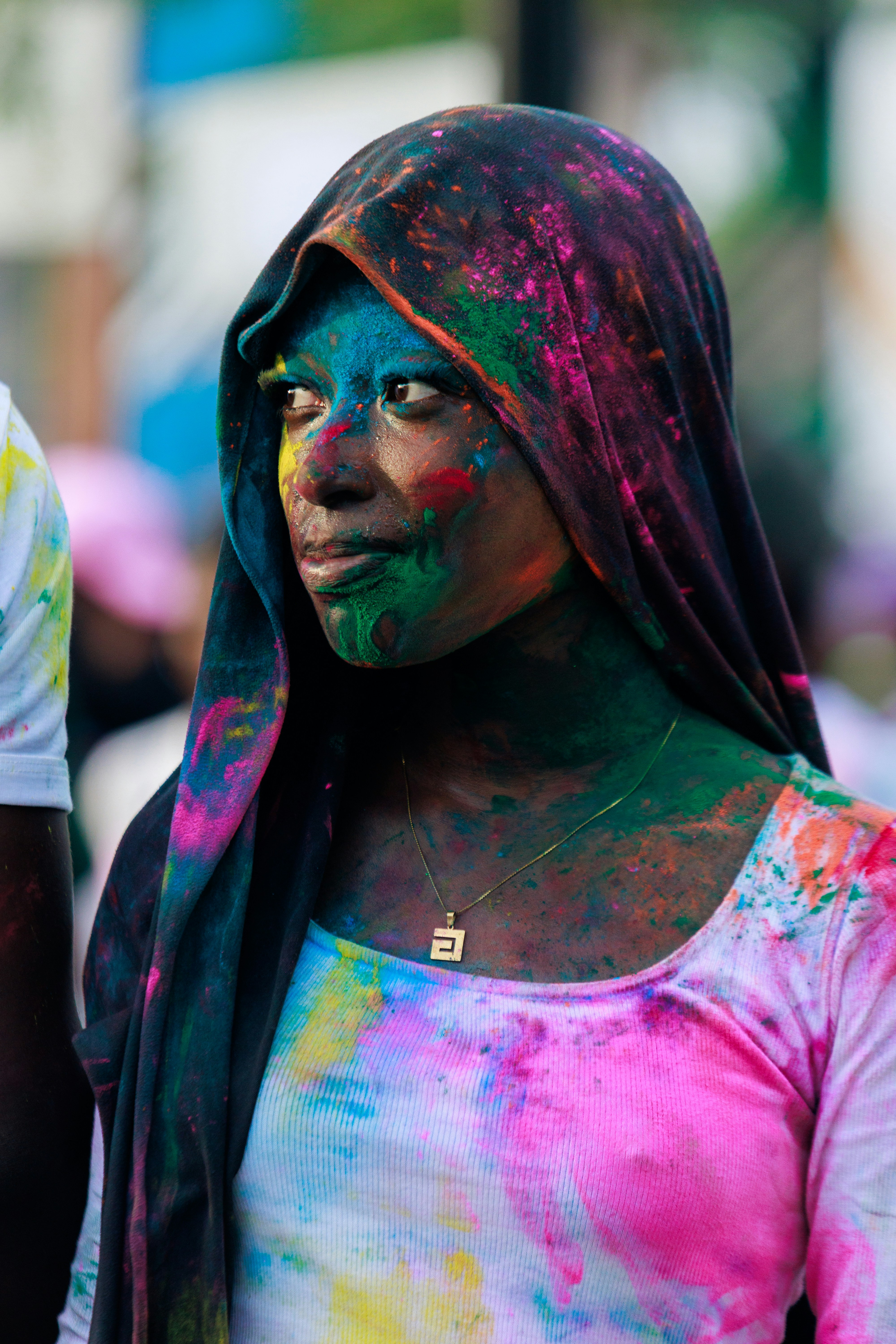 A woman with colorful powder on her face and clothes.