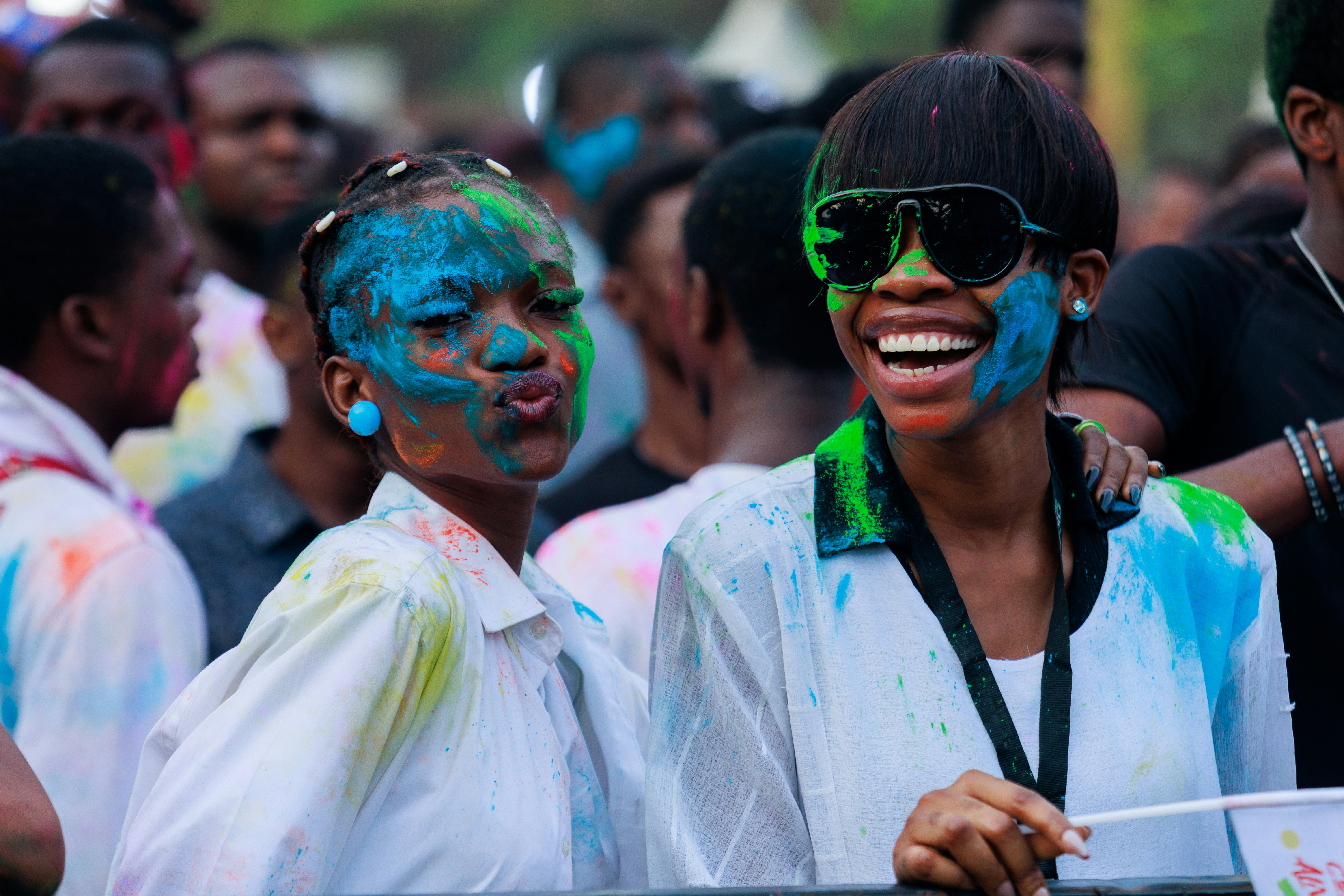 Two women with colorful powder on their faces