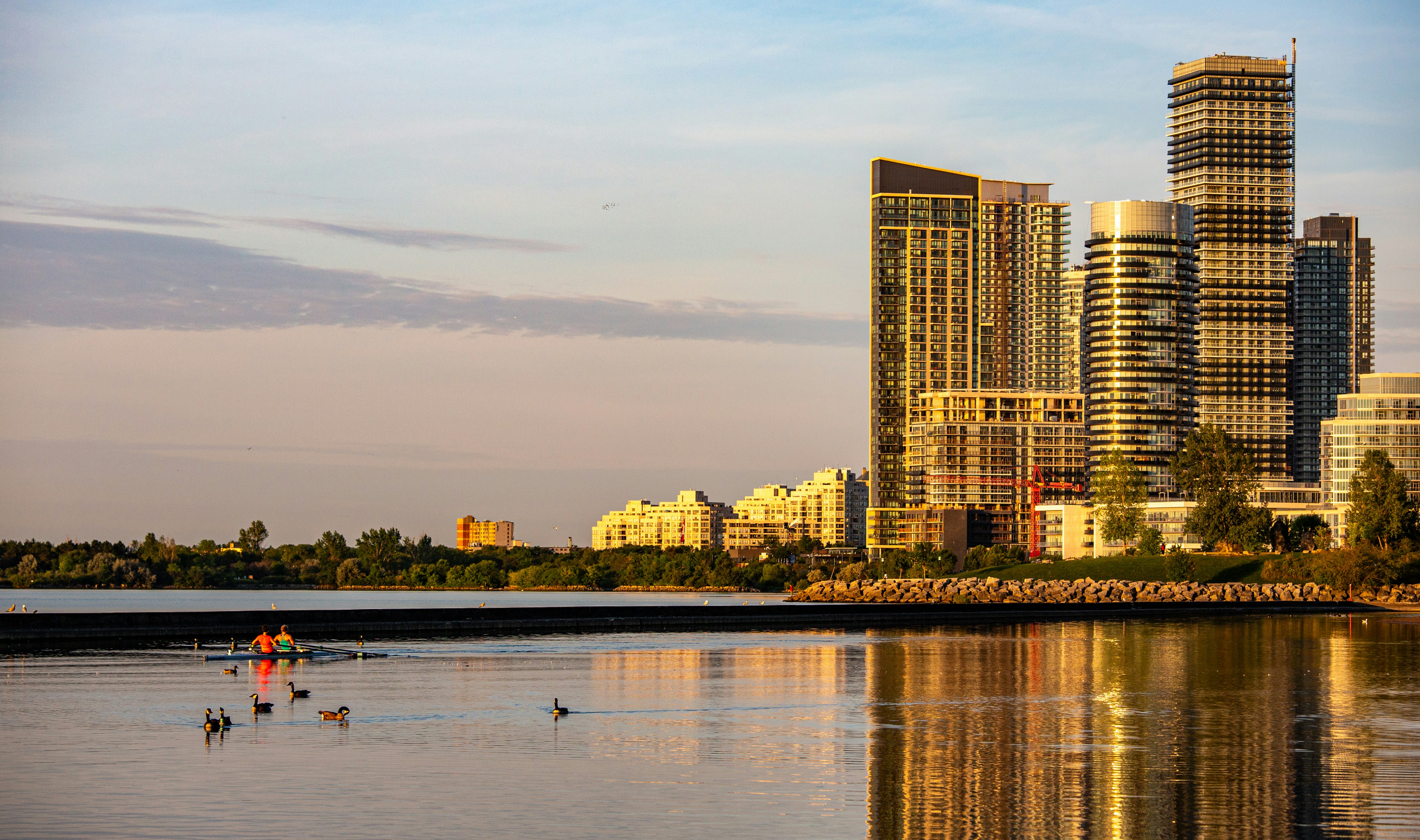 Sunlit Skyline Quietly Reflects on a Calm Riverside