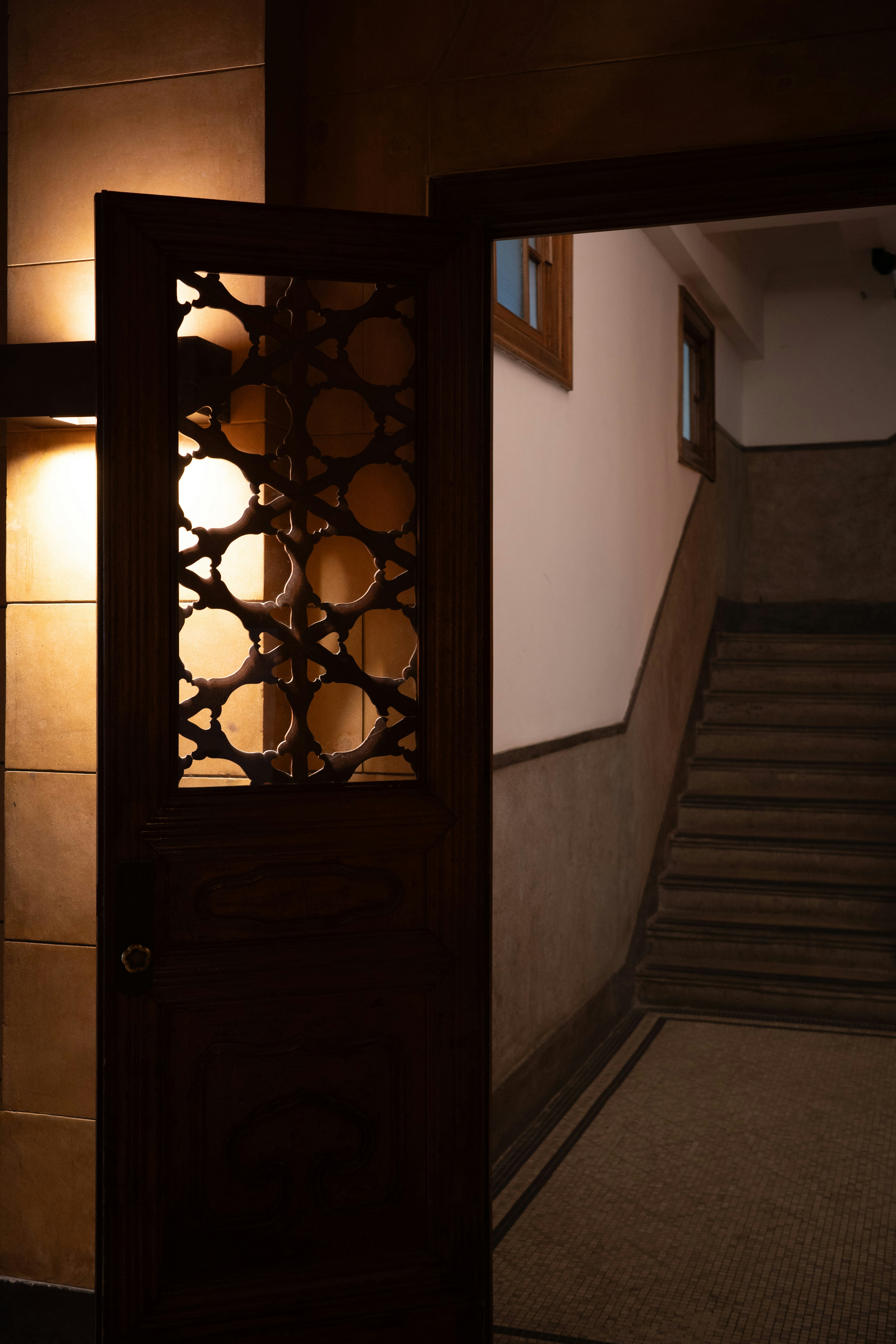 Doorway into Warm Light: An Antique Lattice Pane Opens to a Stairswell