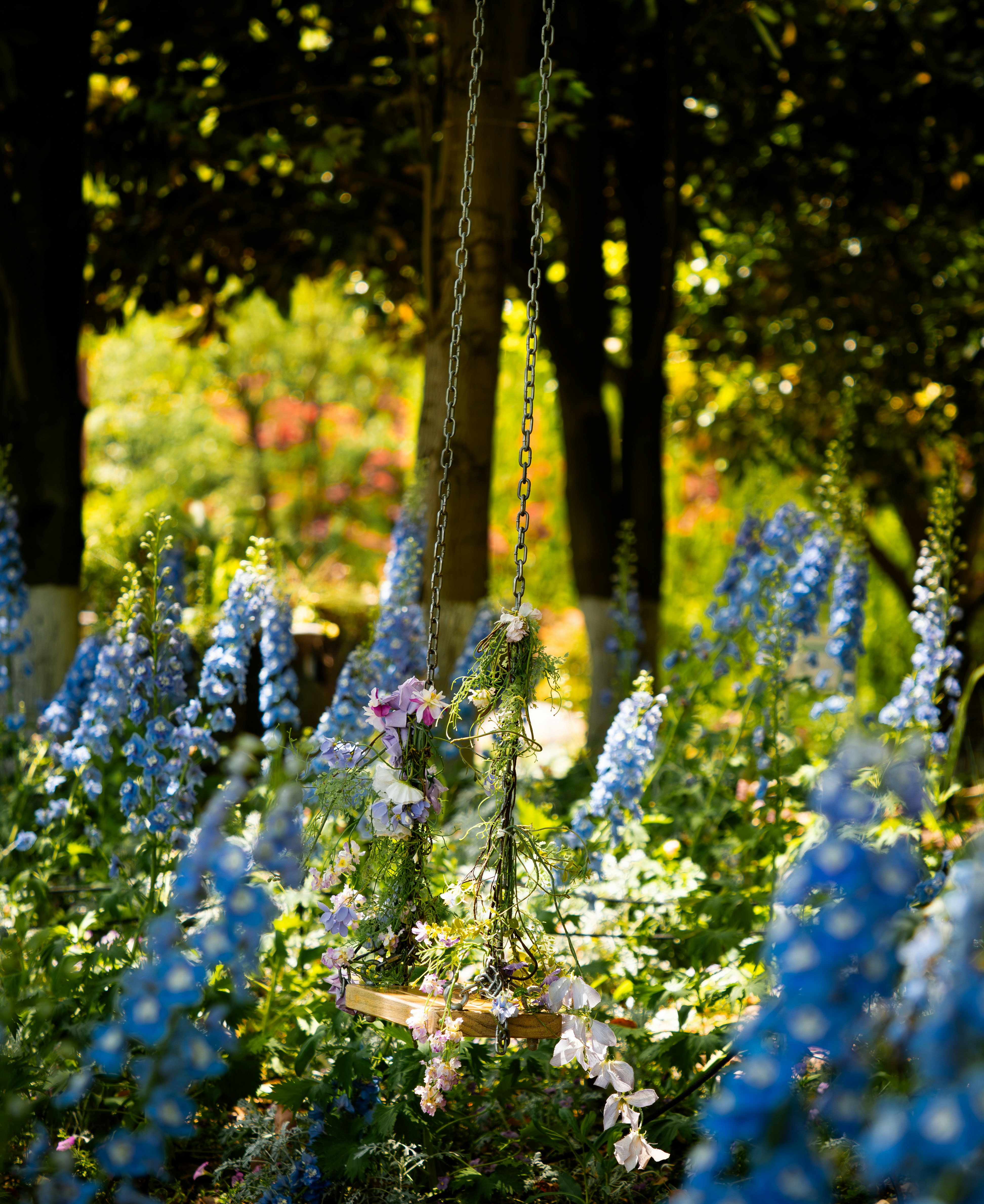 Hanging floral cradle amid bluebells and dappled light