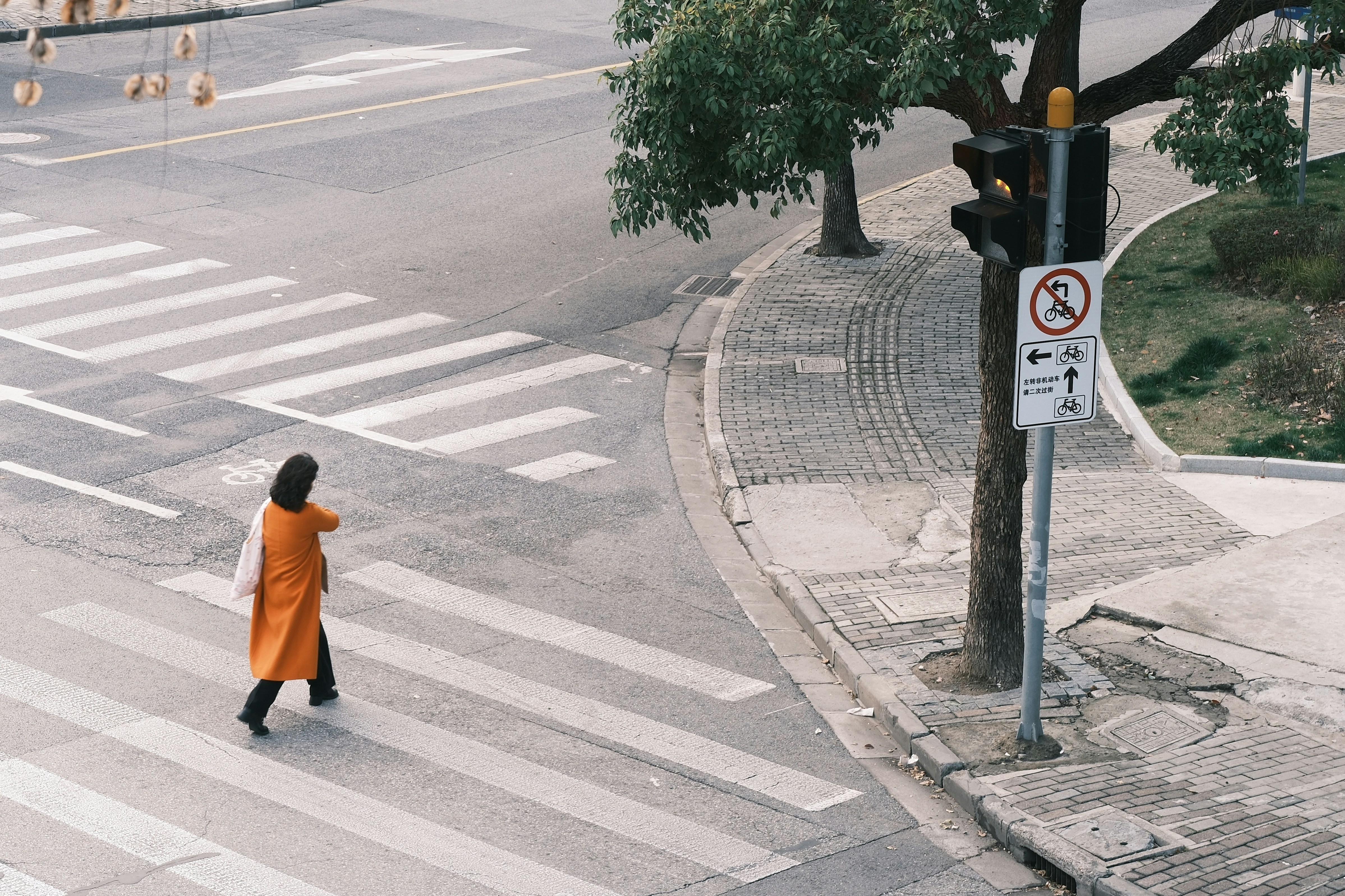 Crosswalk Moment: Orange Coat on a Quiet City Corner