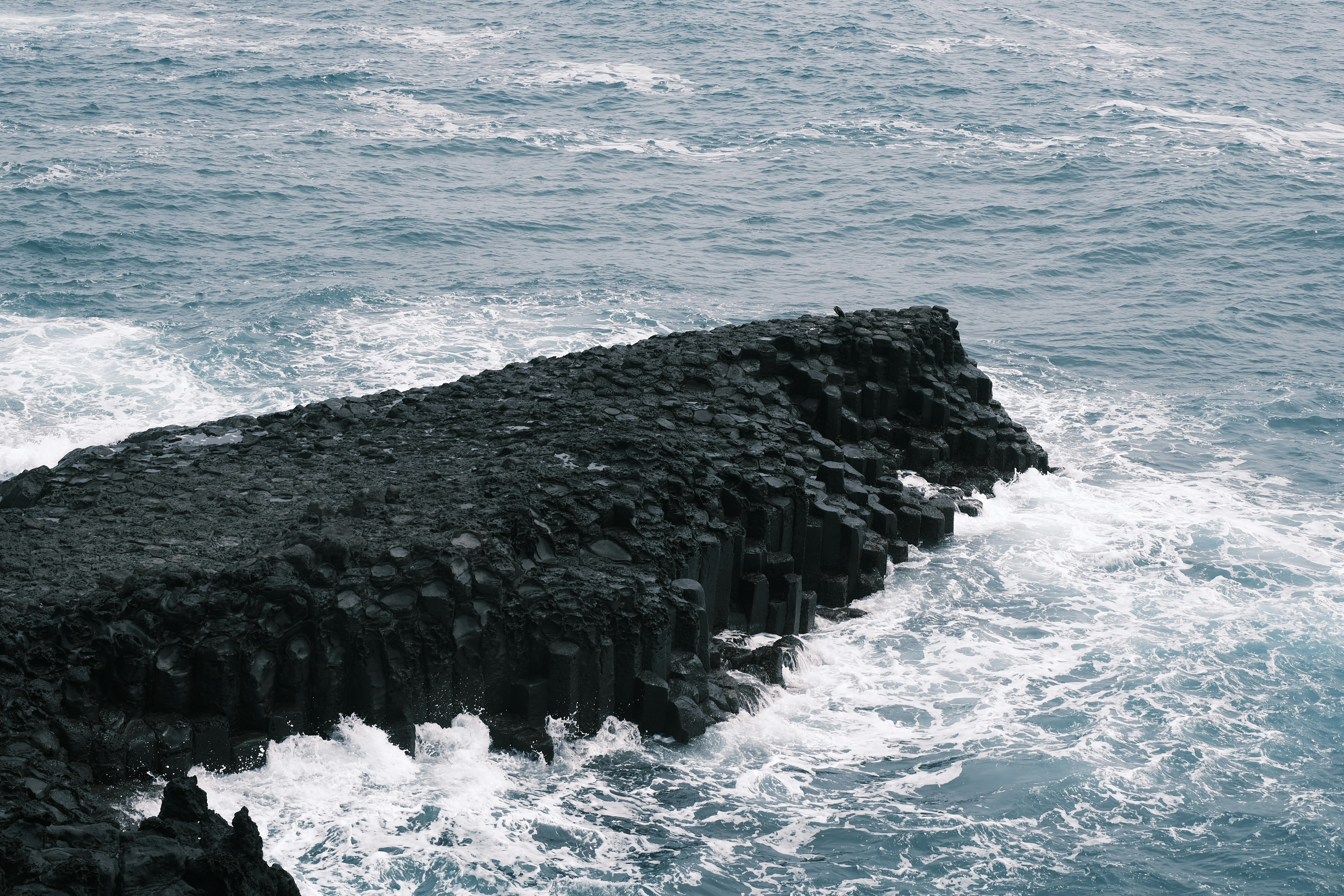 Rugged basalt breakwater Reaching into the Sea