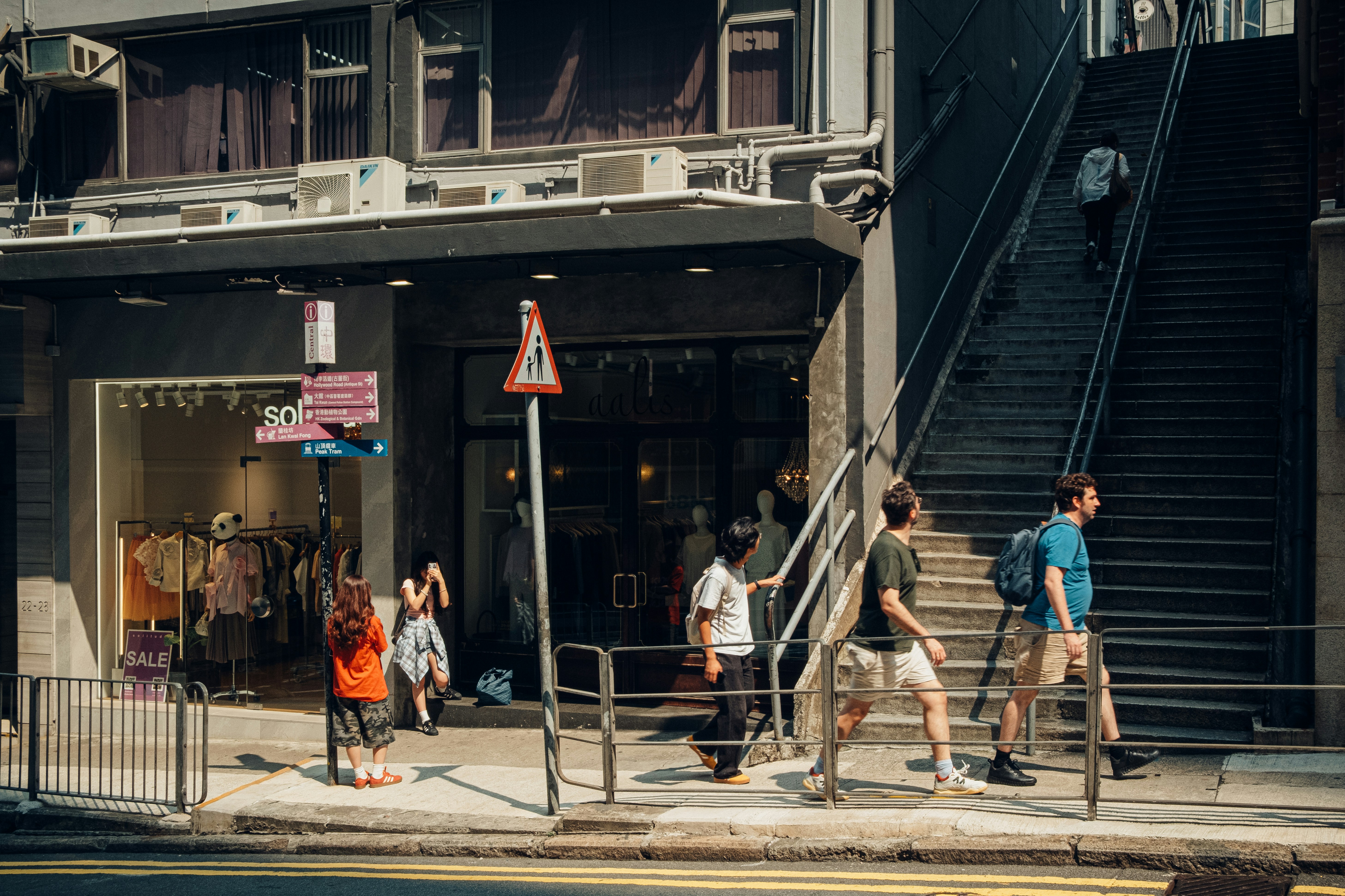 Stroll Through a City Crossing: People, Staircase, and Shopfront