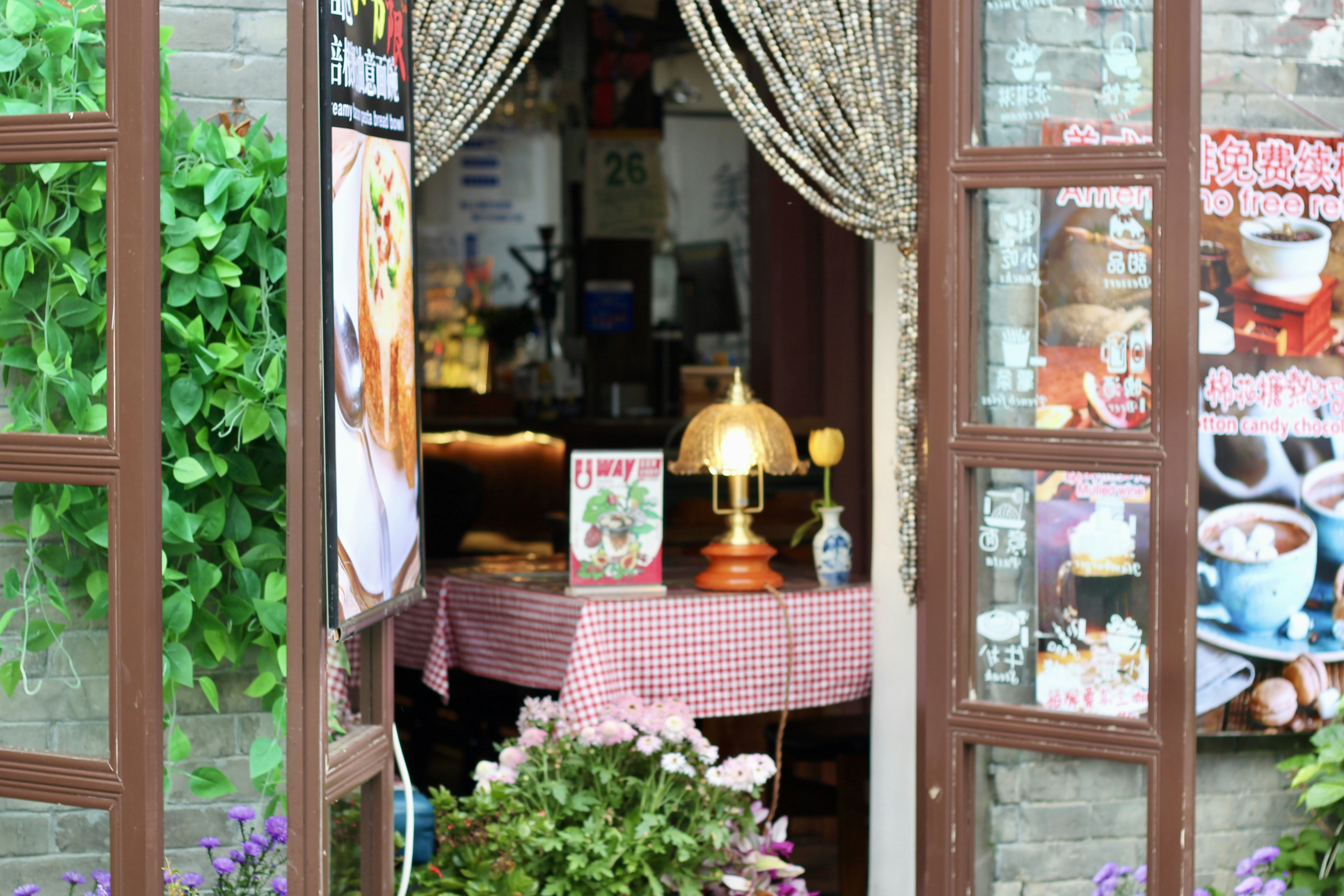 Cozy Café Doorway Framed by Greenery and Warm Light