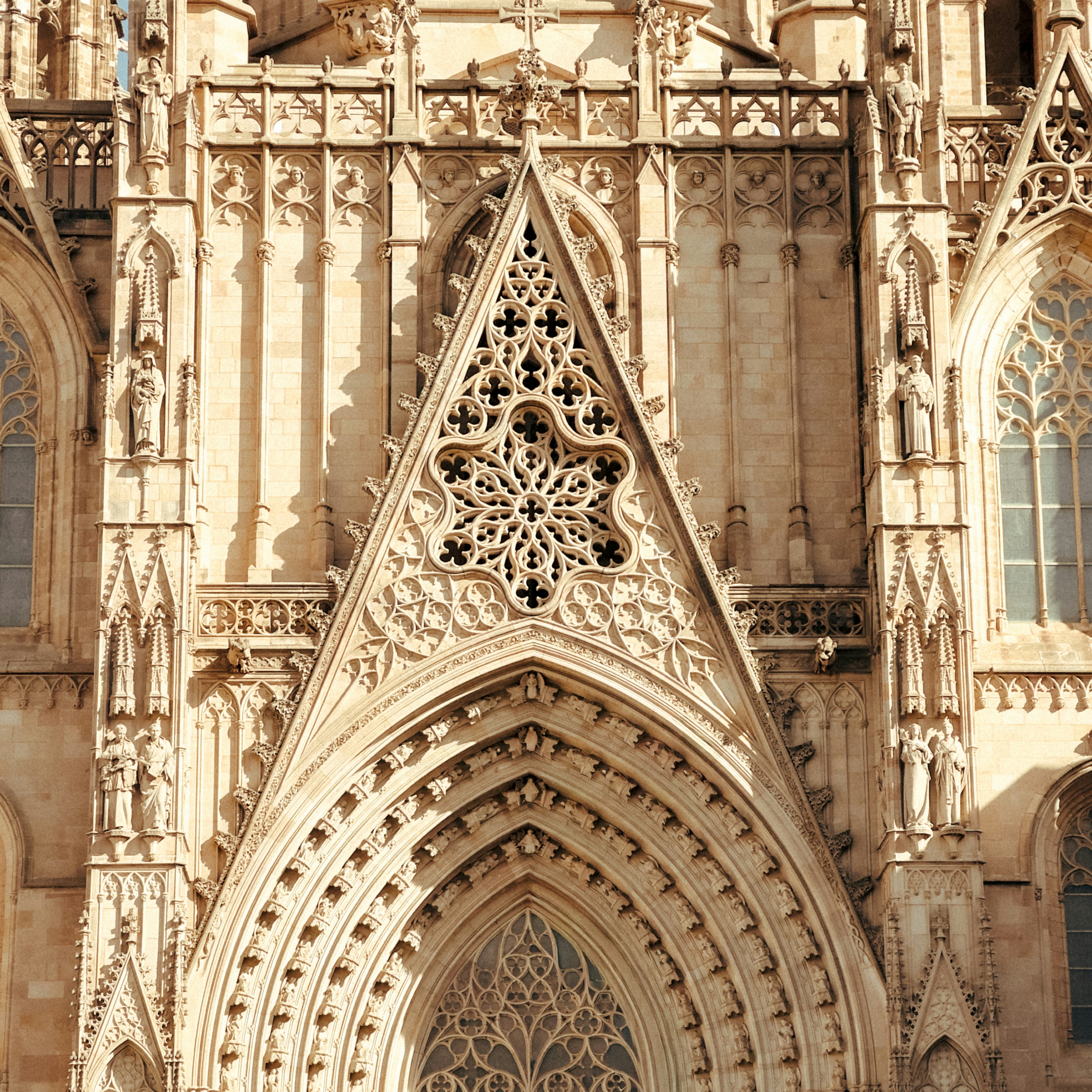 Gilded Gothic Portal: Sunlit Tracery of a Cathedral Facade