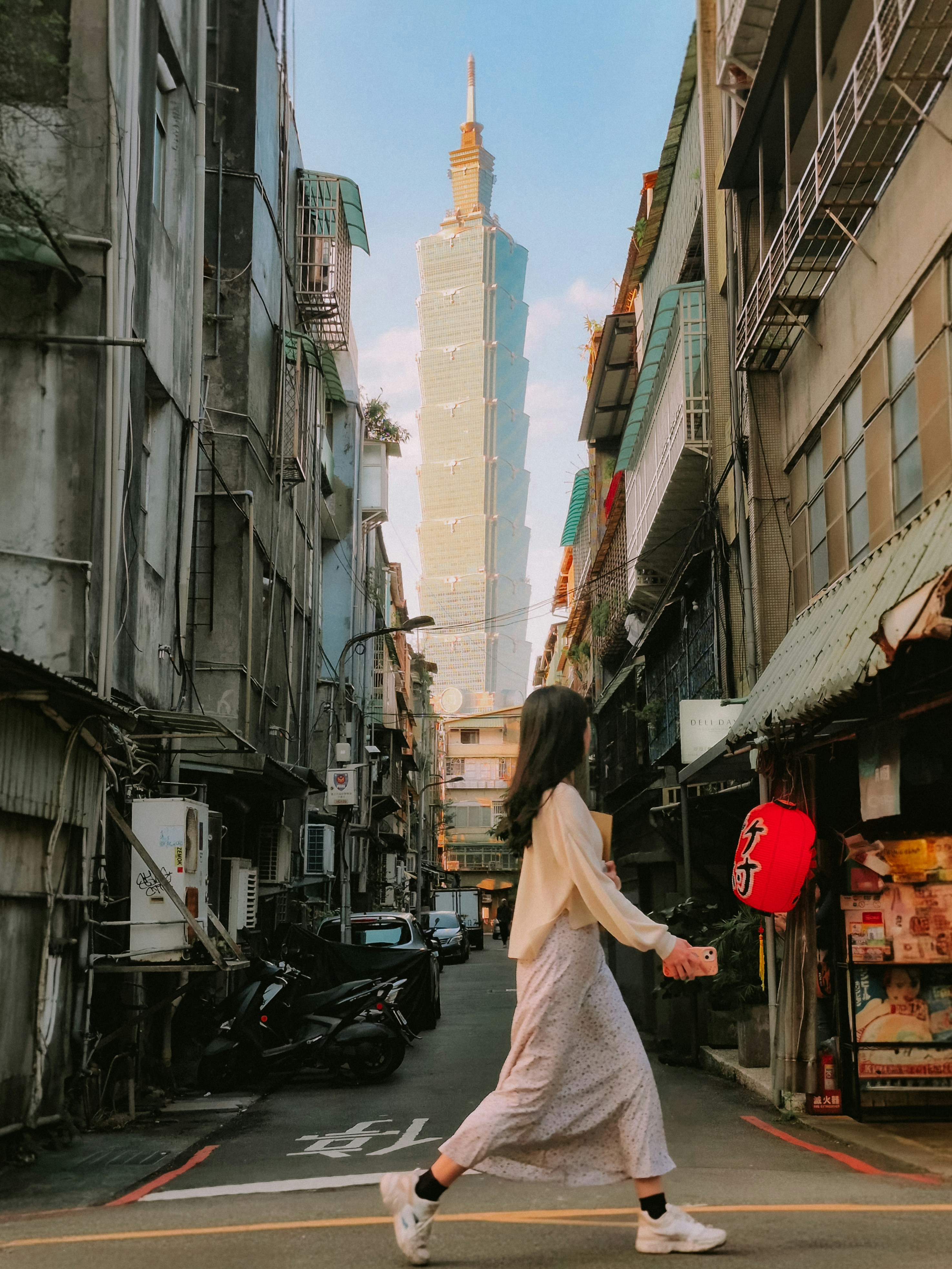 City runner under the Taipei-like tower: A street portrait with a distant skyscraper