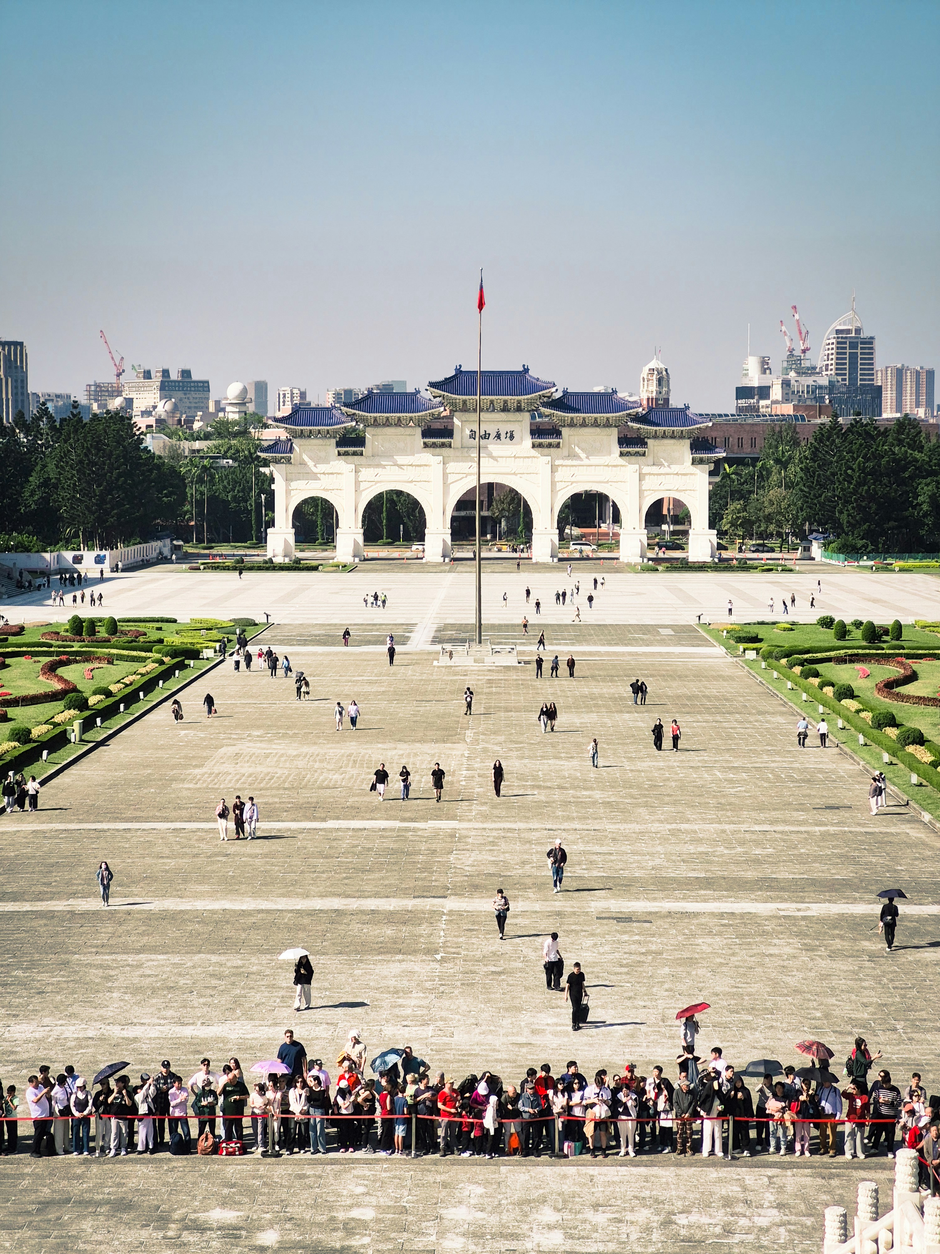 A ceremonial vista: the grand archway and crowd beneath a blue sky