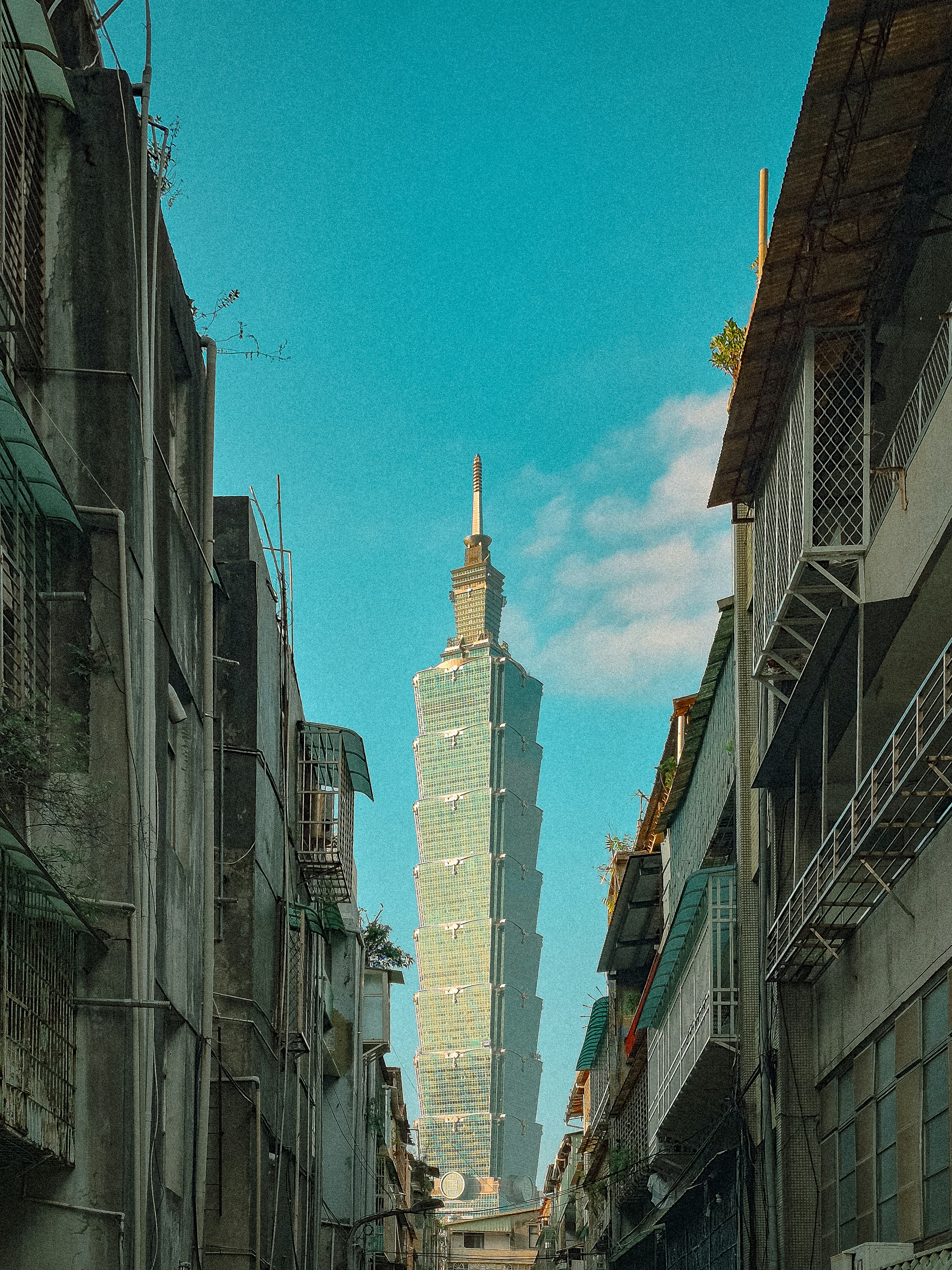 Towering Silence: Taipei's Skyward Needle Framed by Narrow Alley