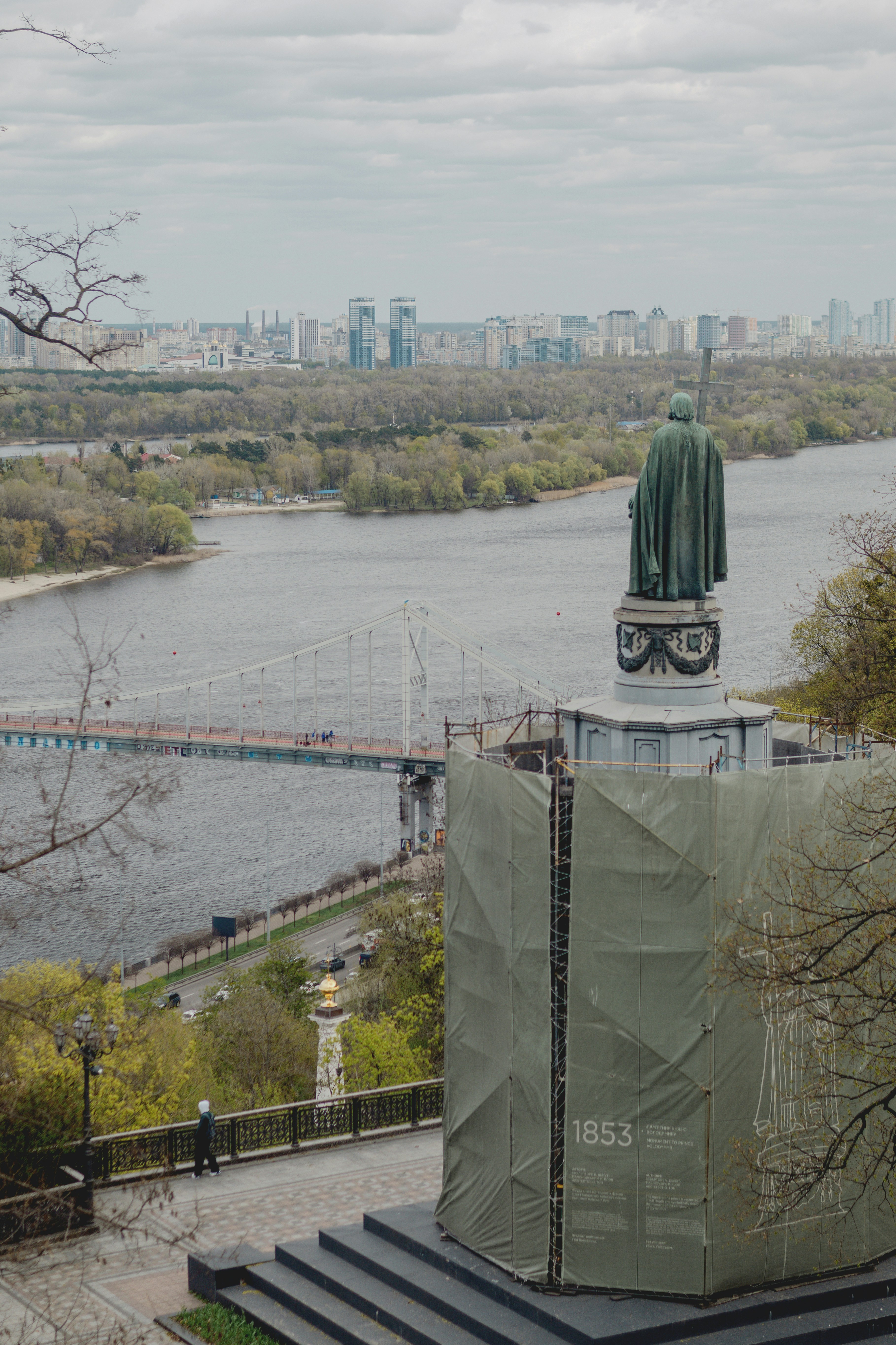 Rising from the Park: a Statue Overlooked by the River and Bridge