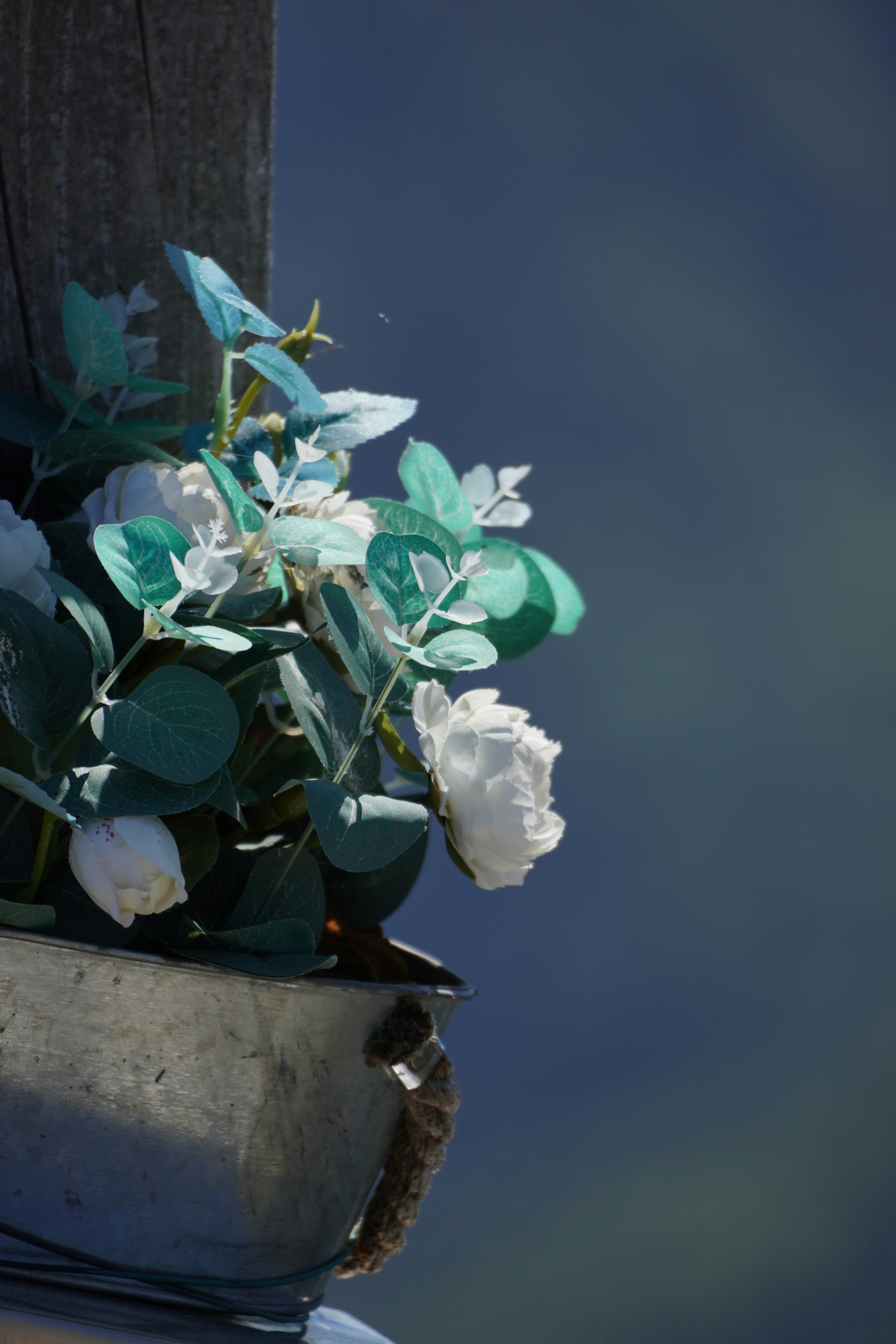 White Rose Bouquet Adorning a Rustic Metal Pot
