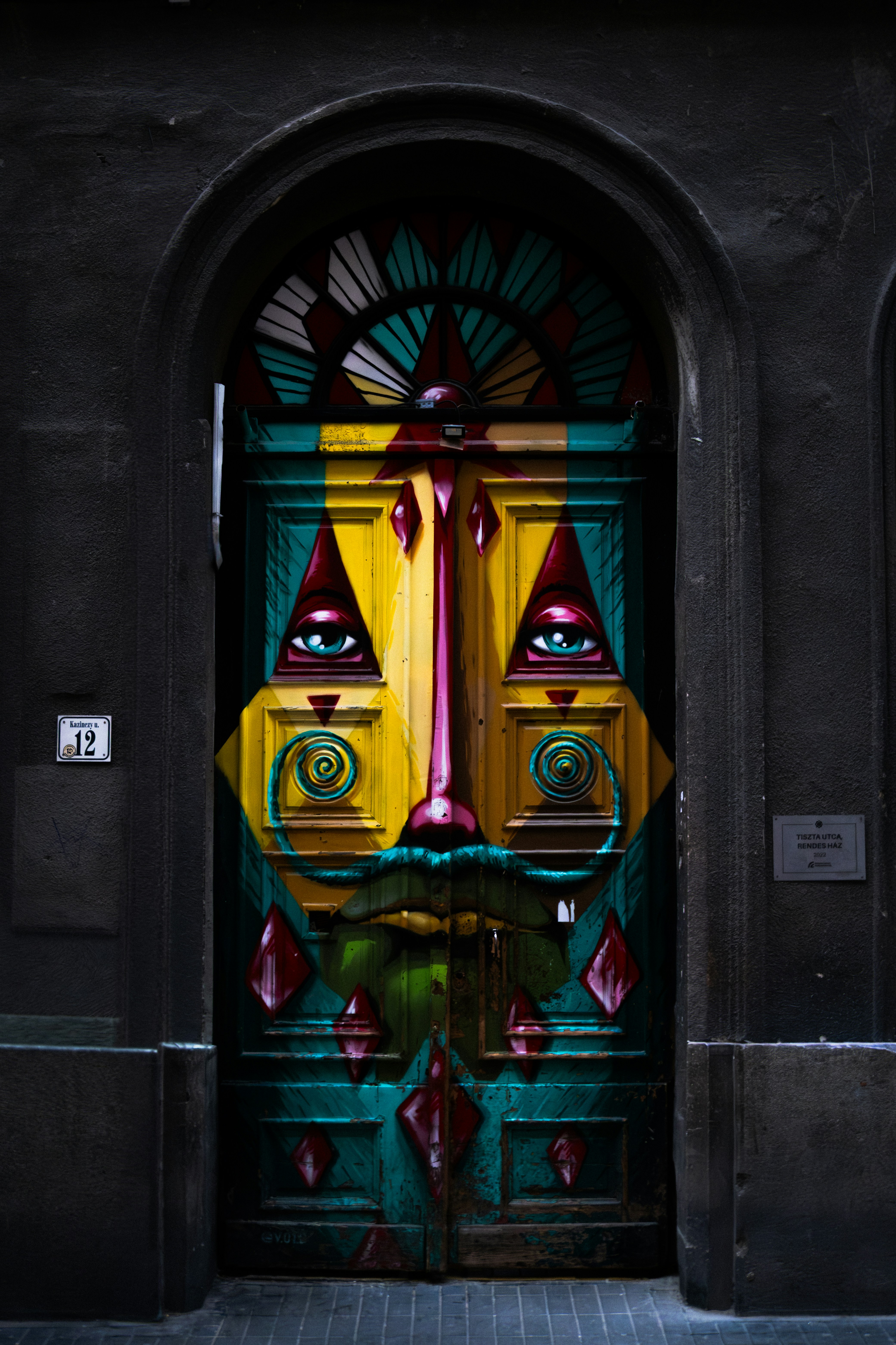 Doorway of Color: A Faceted Face Emerges from the Arch