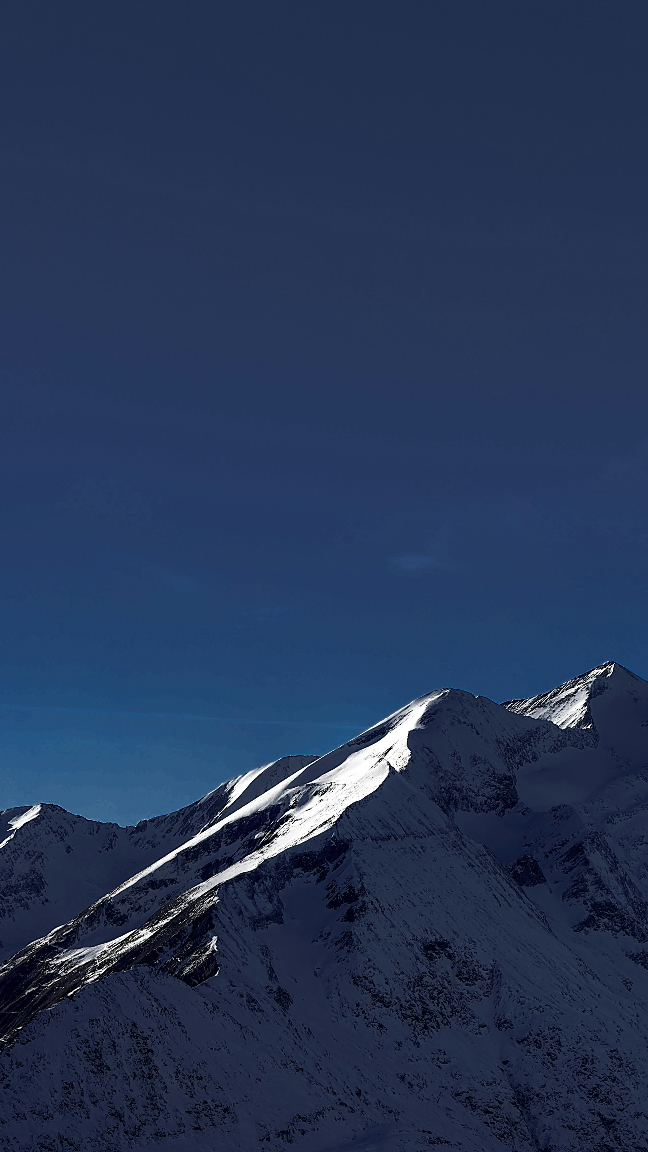 Snow peak under a cobalt sky: a sculpted ridge catching the last light