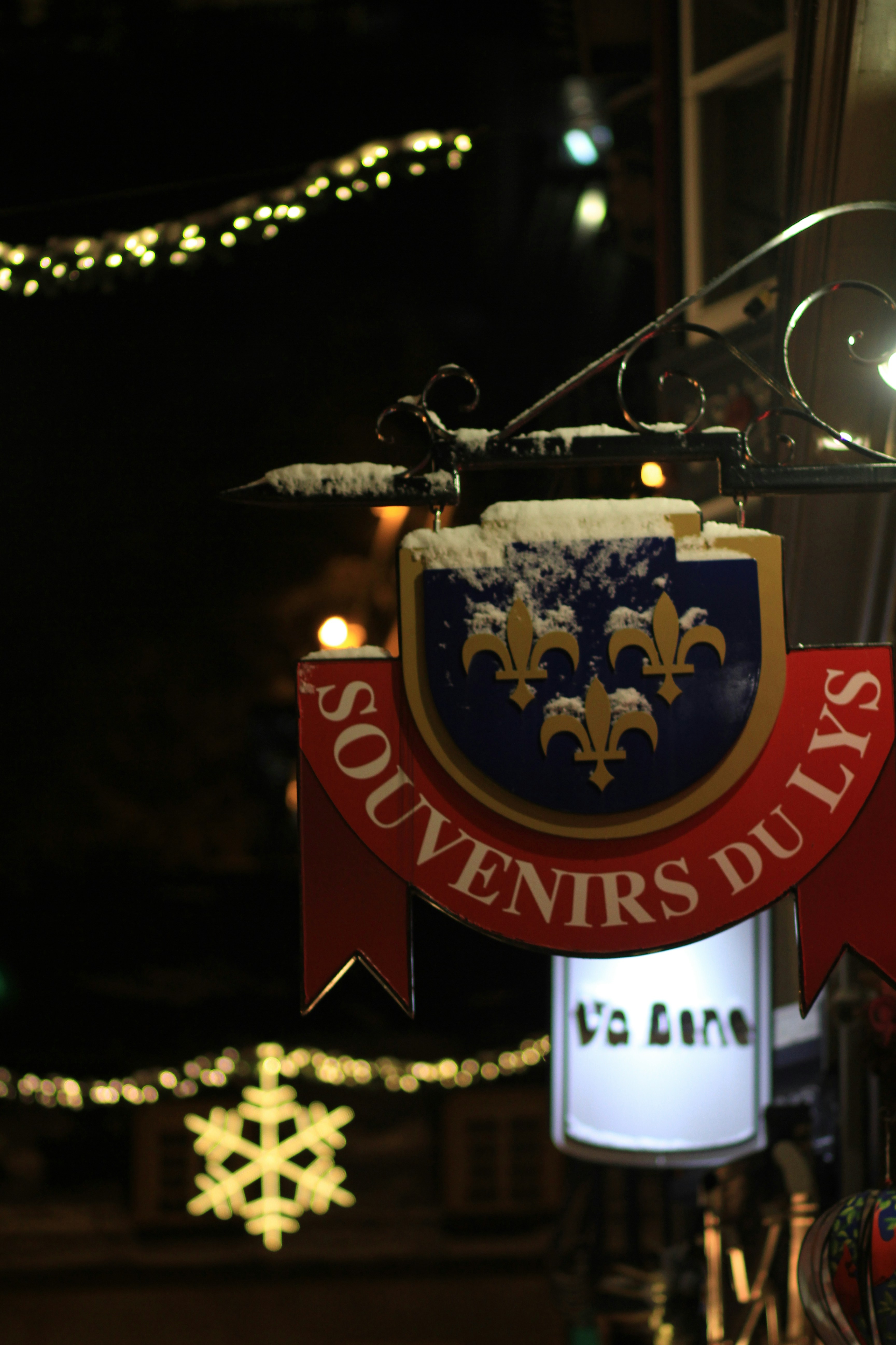 Fleur-de-lis Crest Aloft Over Cozy Night Market Signage