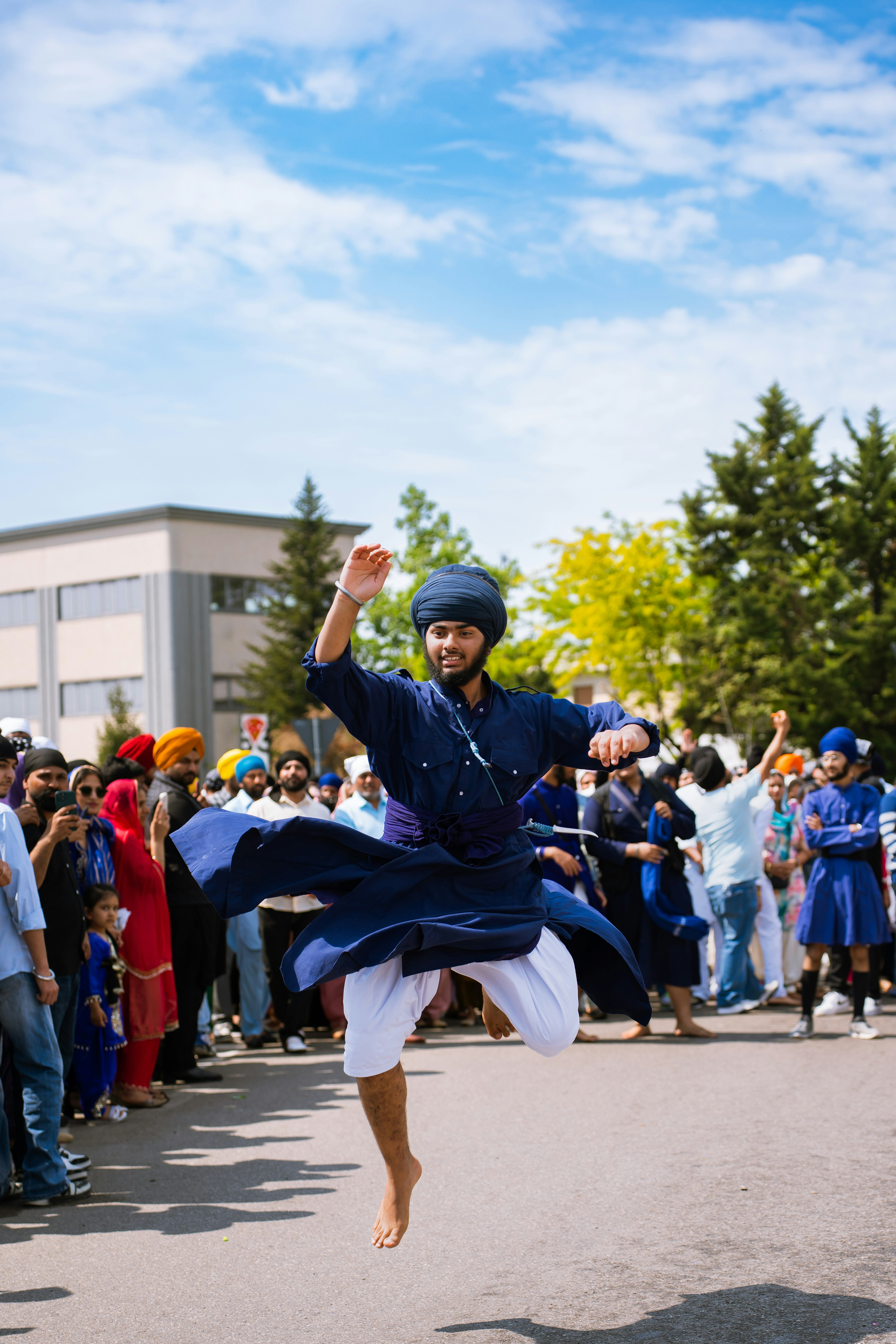 Energetic Bhangra Leap Under a Crowd of Cheerful onlookers
