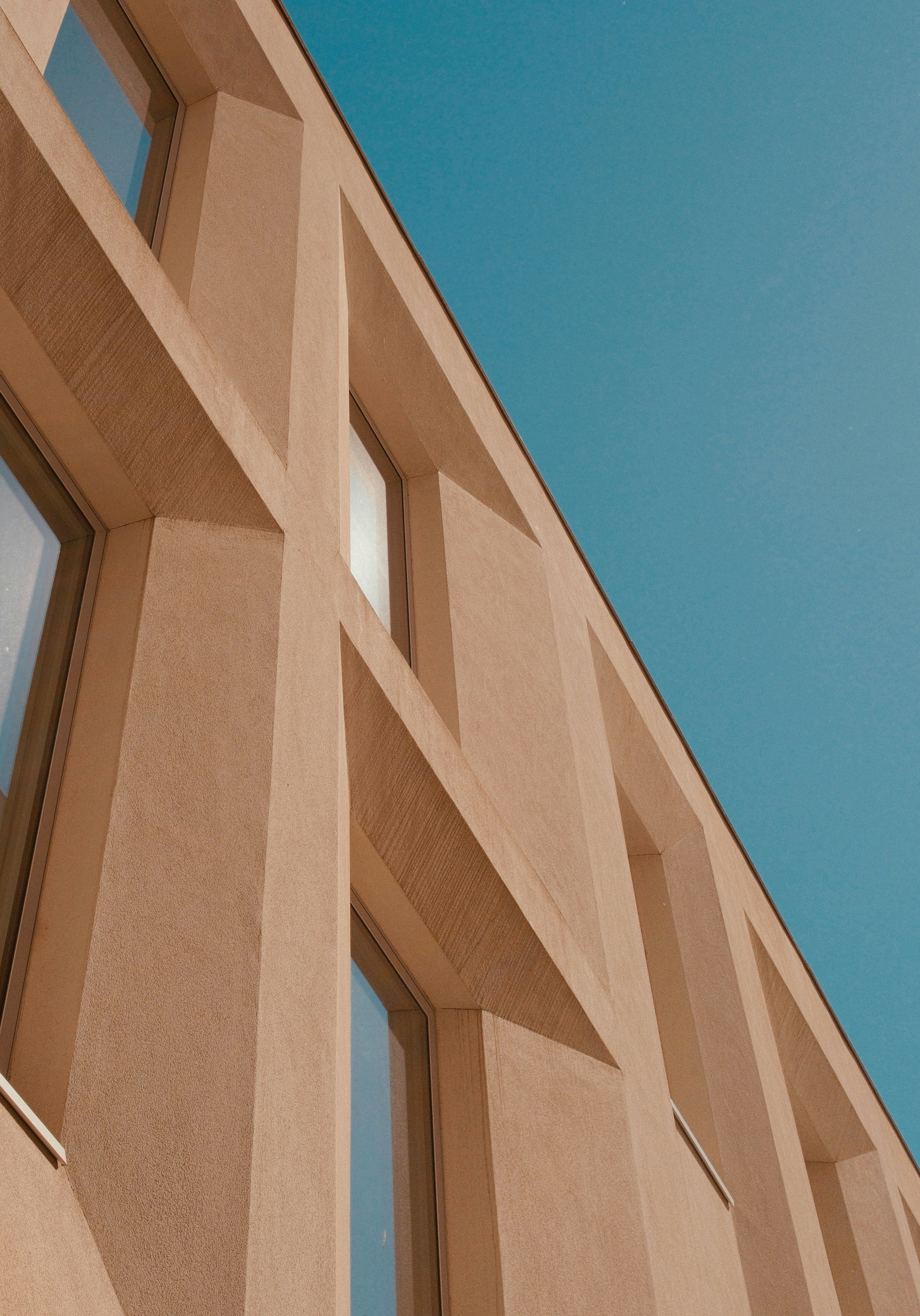 Angle of Light: A Peach-Tinted Facade Reaches for the Sky