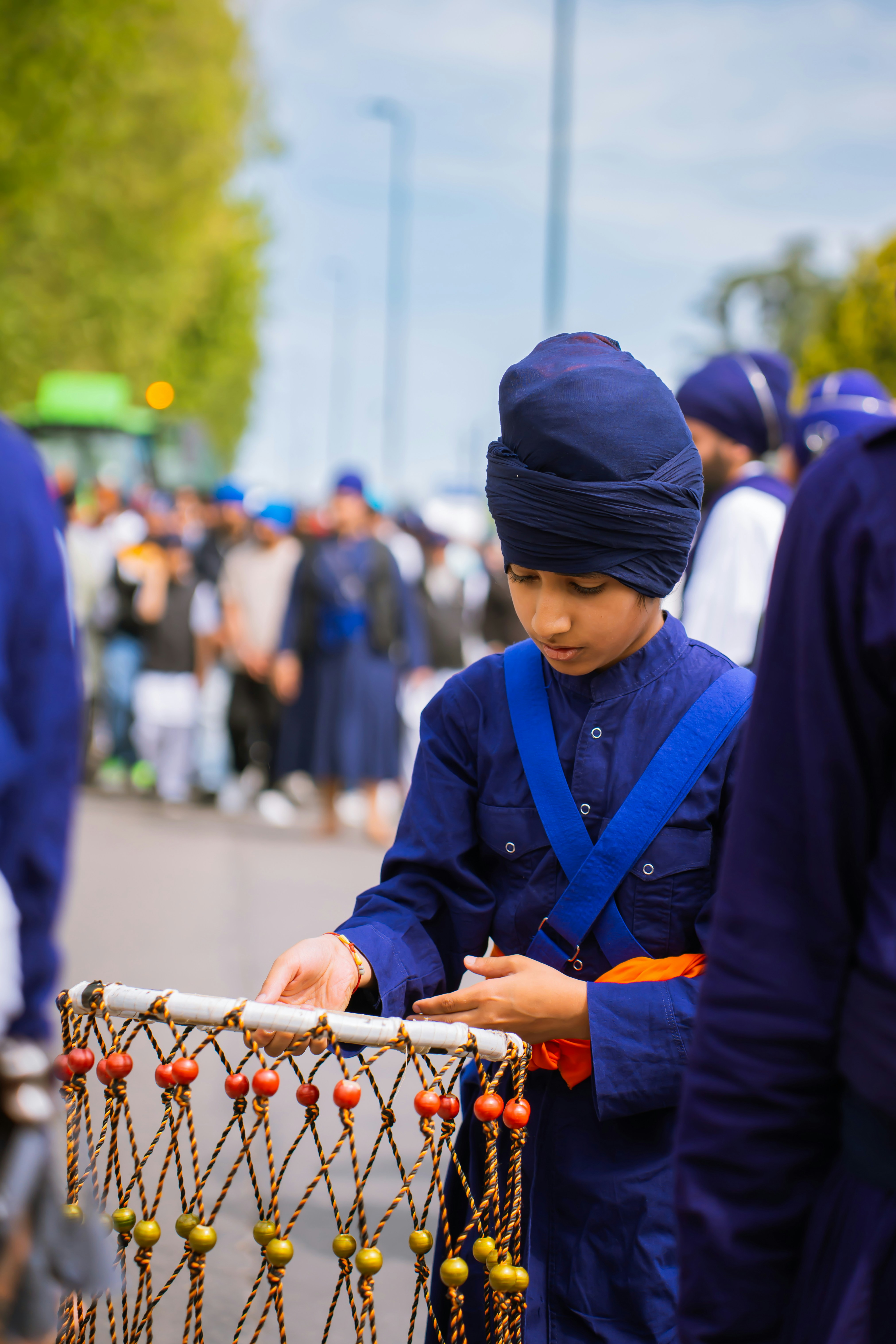 Blue Garb and Beaded Cord: Street Scene of a Young Turbaned Scion Engaging with a Rope Mesh