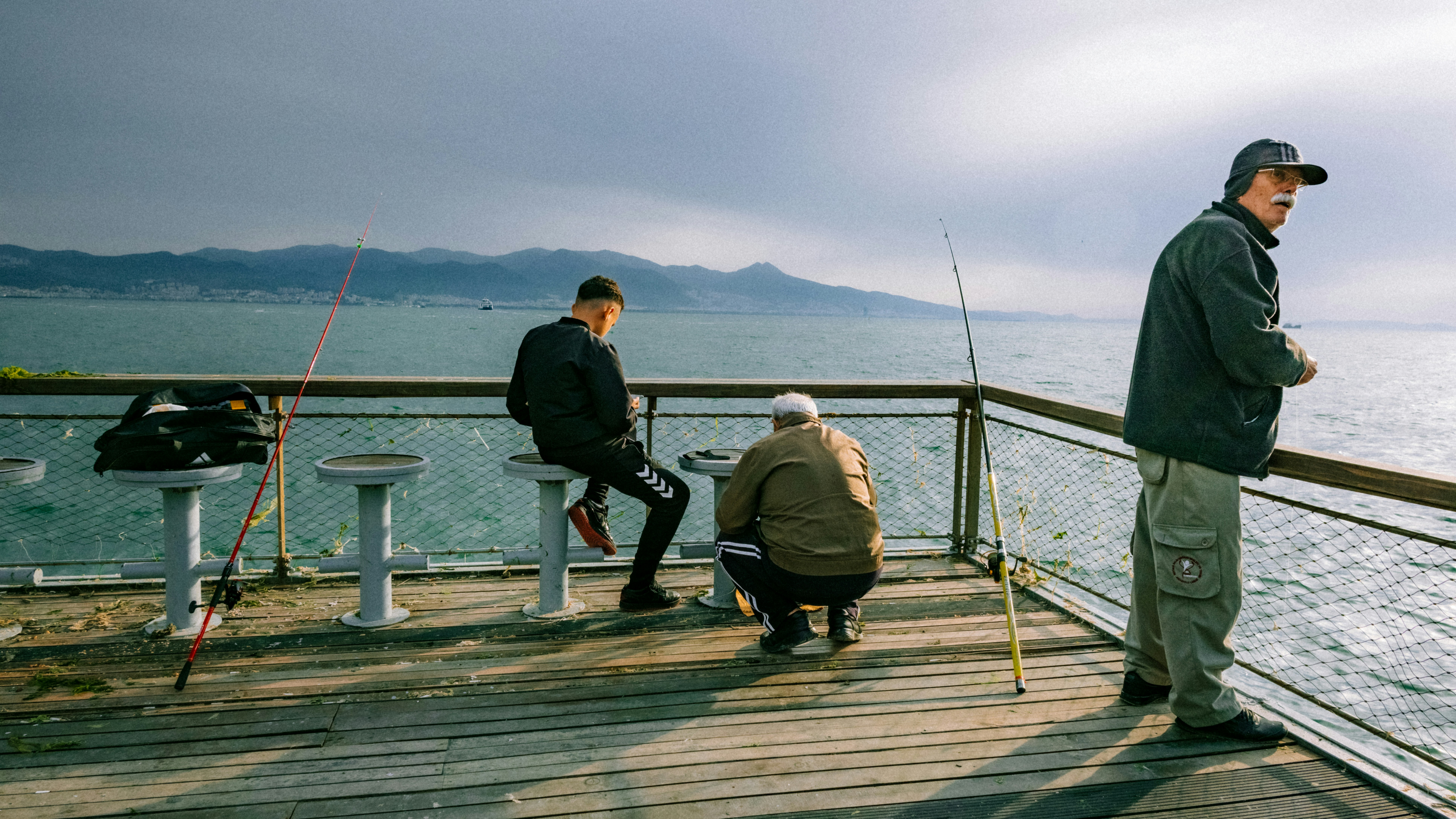 A Quiet Shoreline Break: Anglers on a Weathered Pier