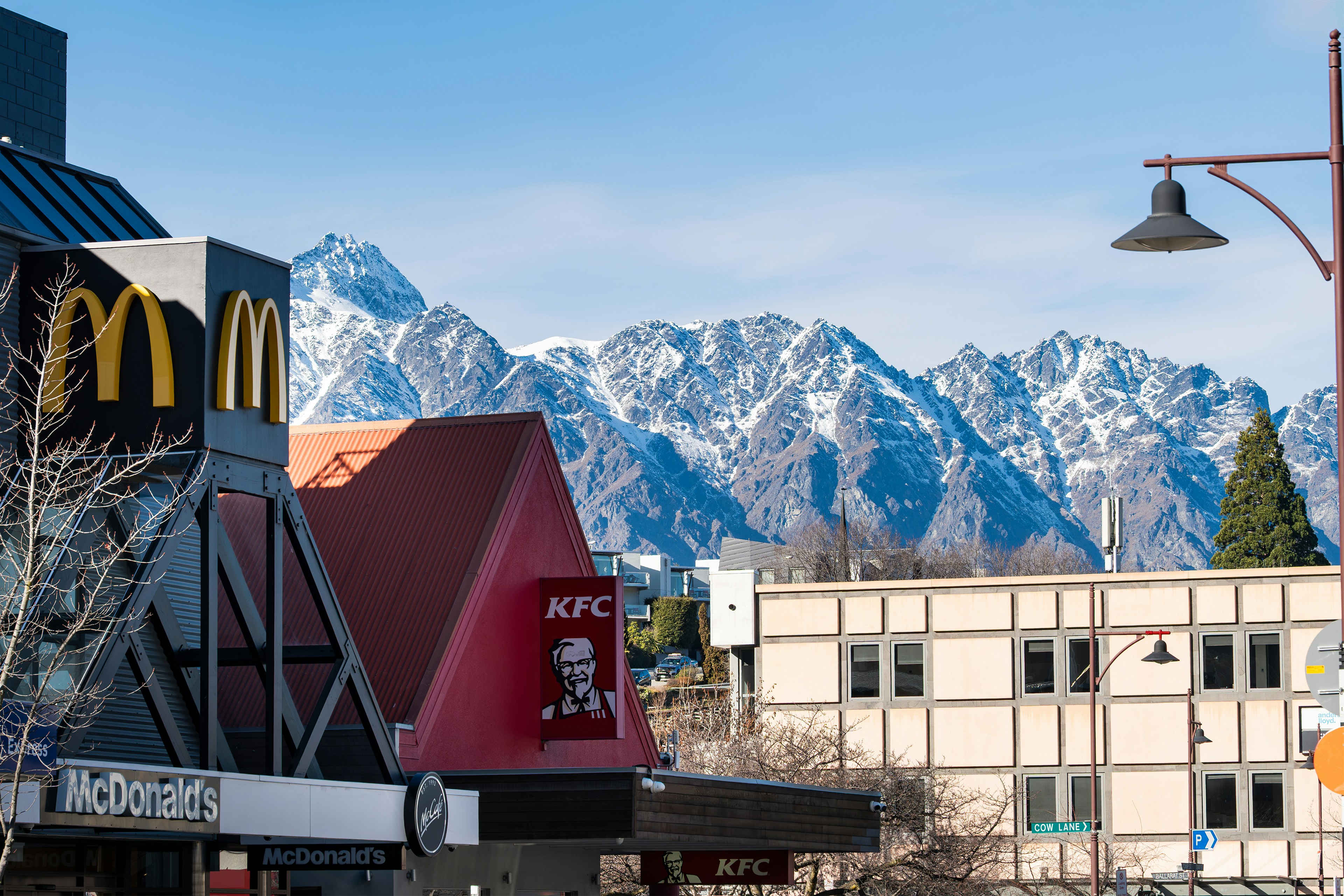 Snow-Capped Peaks Over a Burger Joint Row
