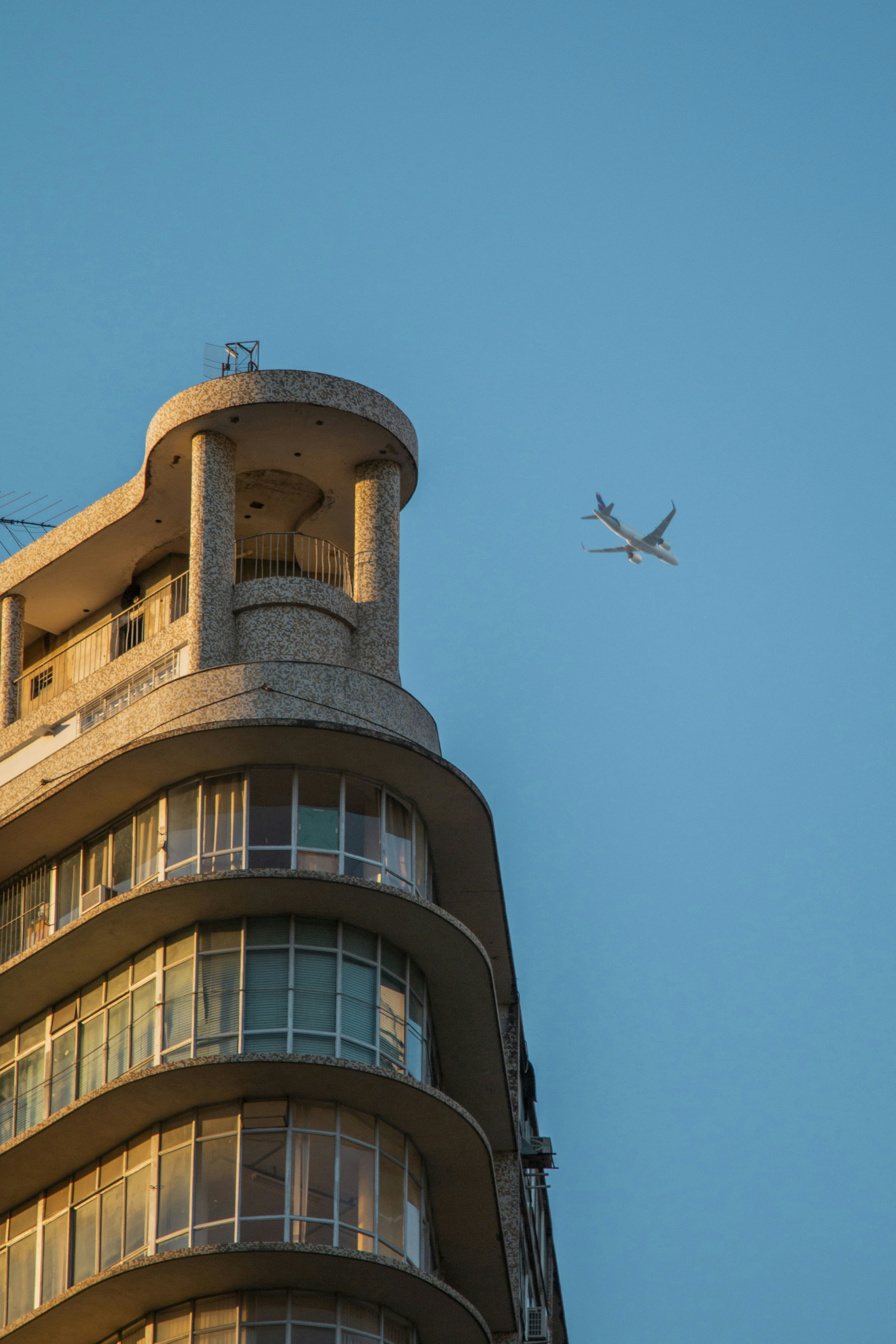 Towered Grace: The Art Deco Building with a Skybound Airliner