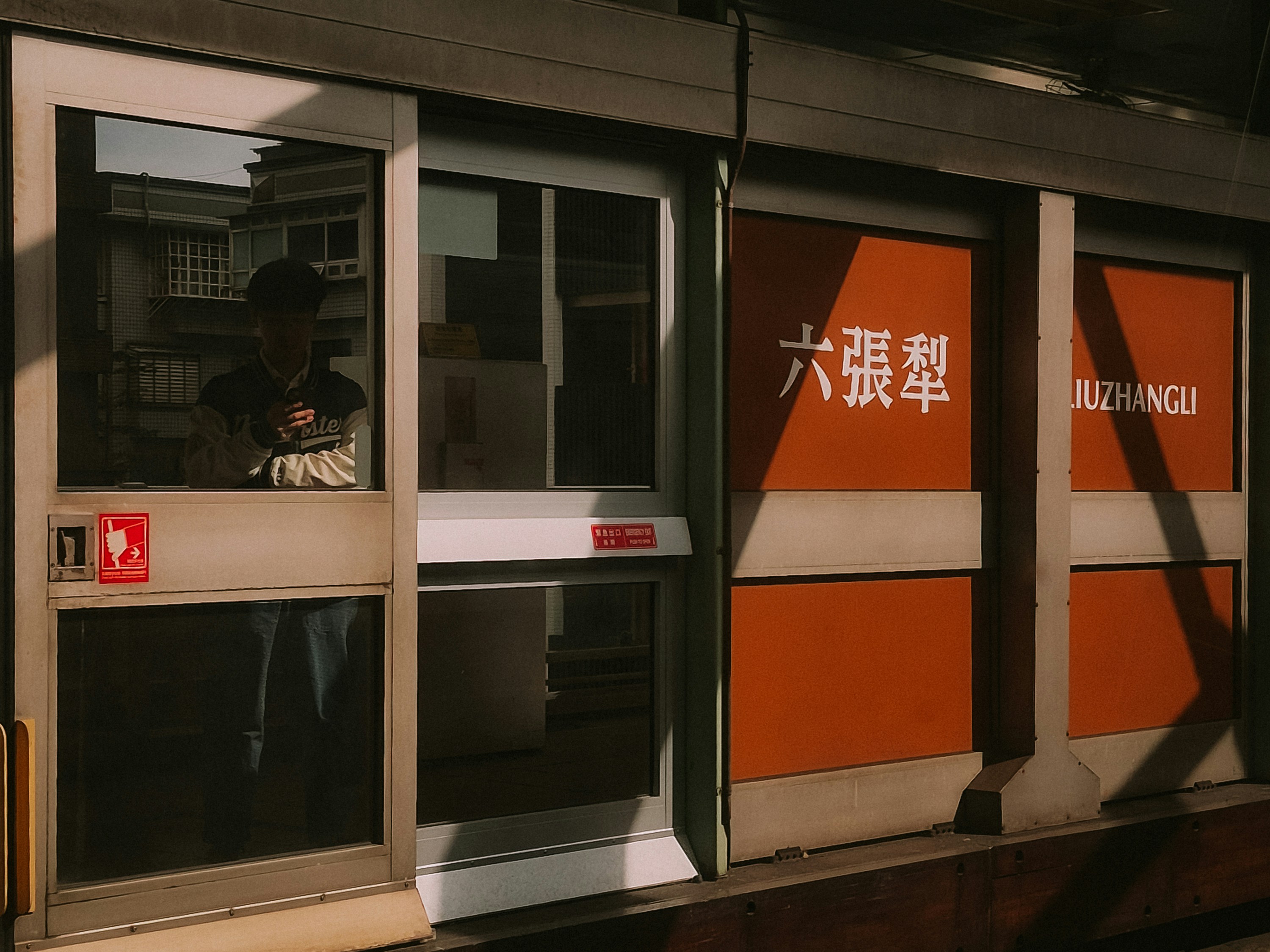 Industrial Orange: Facade Letters and Glass Doors in Evening Light