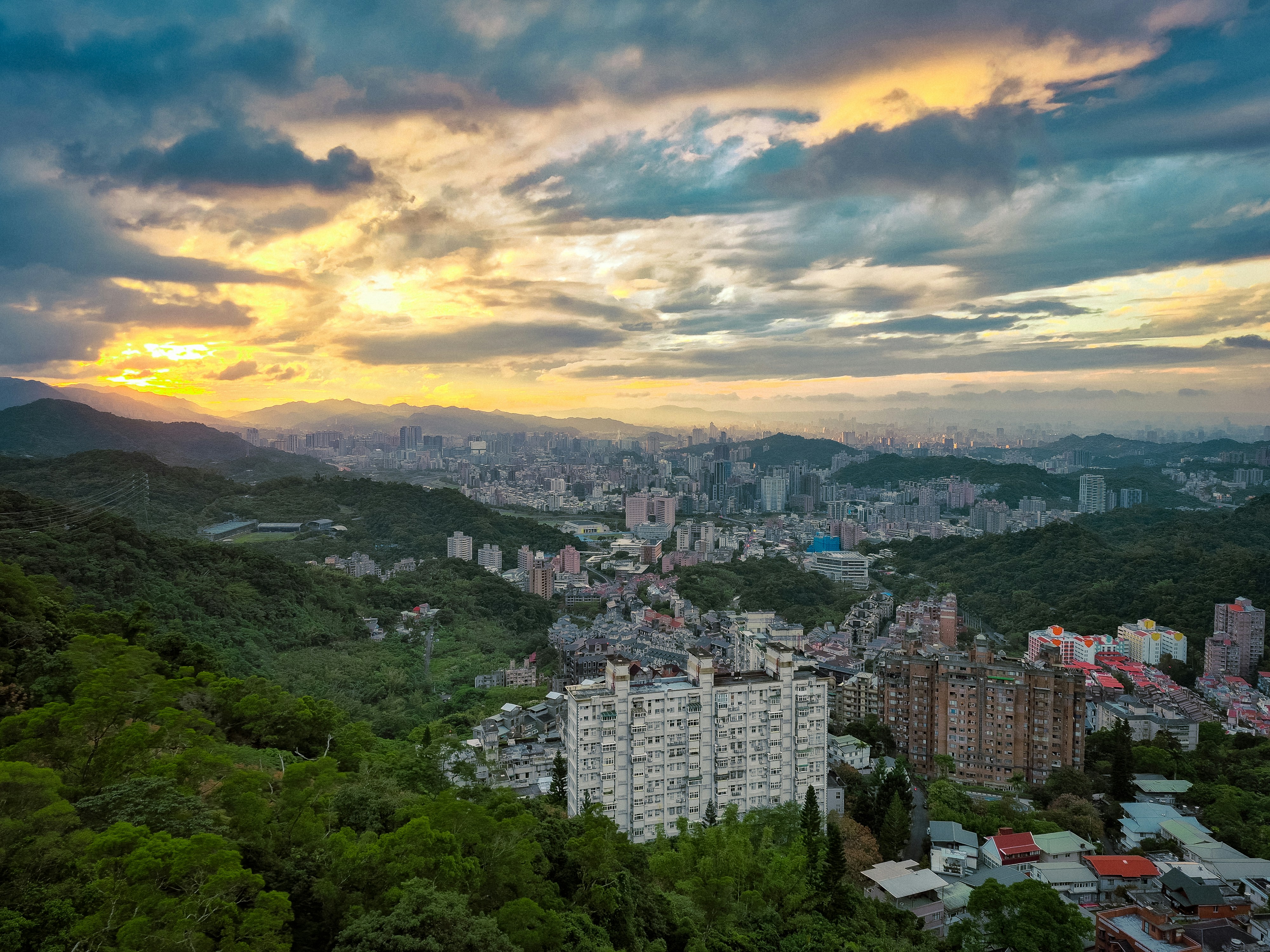Sunset Over Urban Hills: A Panoramic Cityscape
