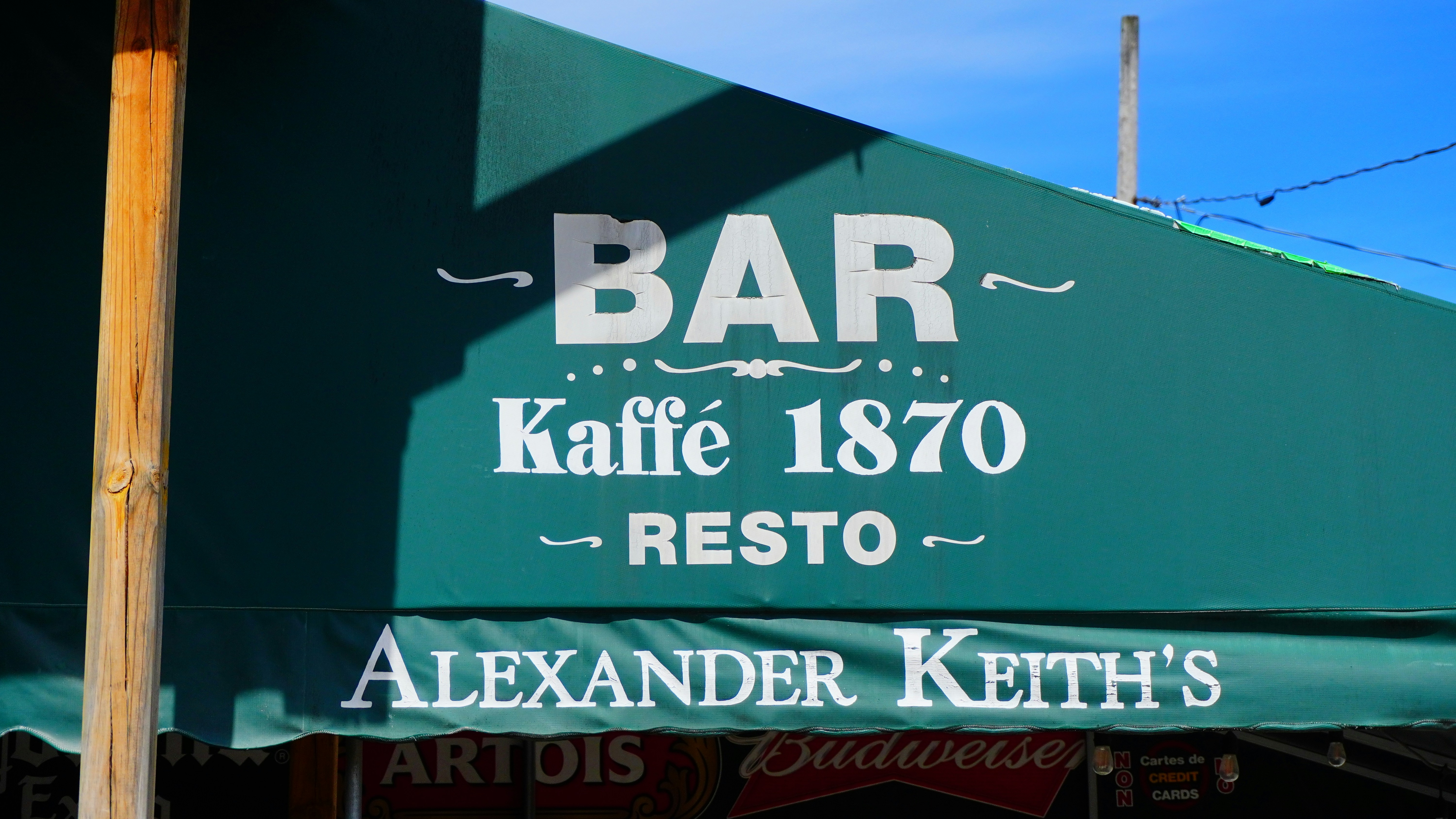 Sunlit Green Awning over Bar Signage