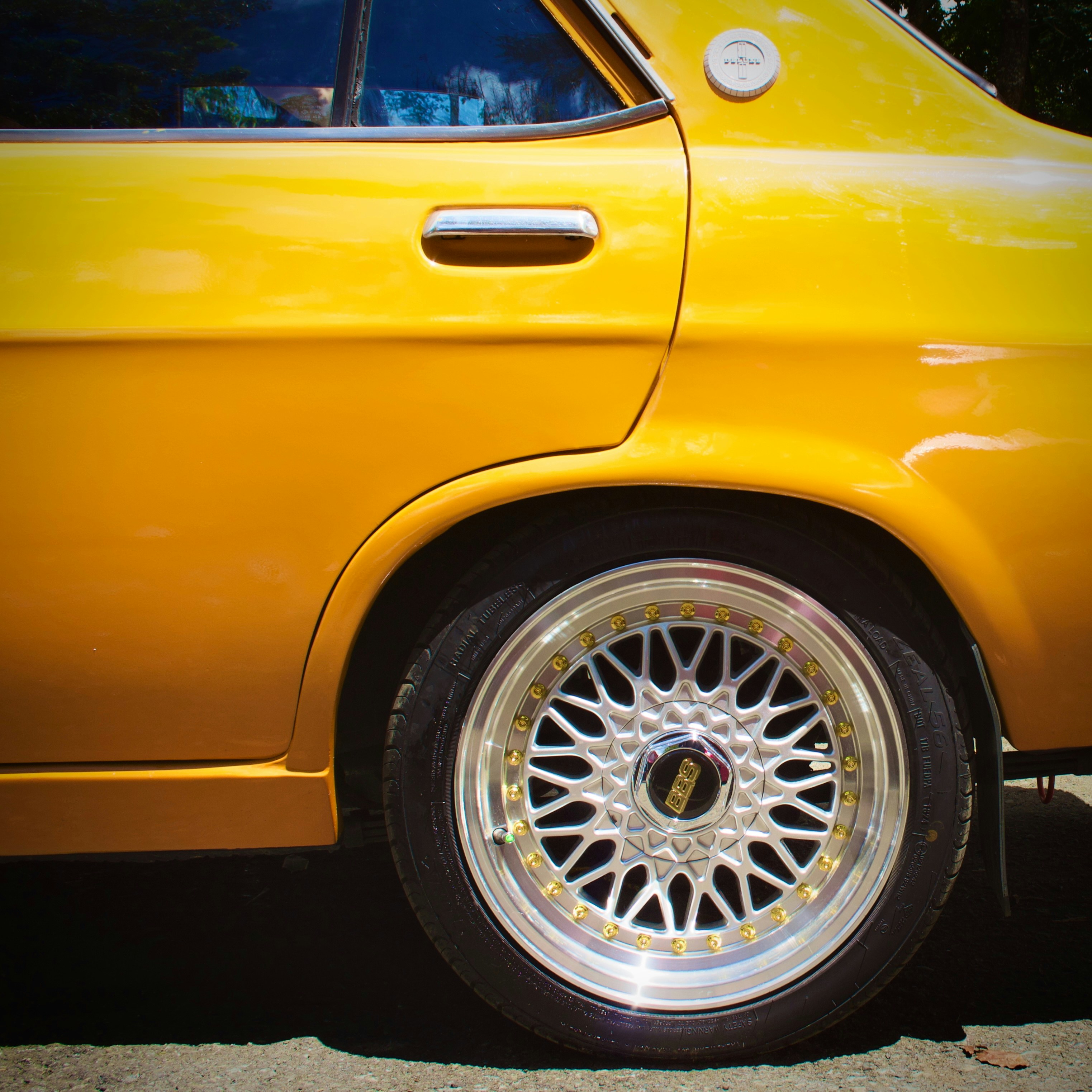 Sunlit Yellow Classic: Close-Up of a Wheel and Door