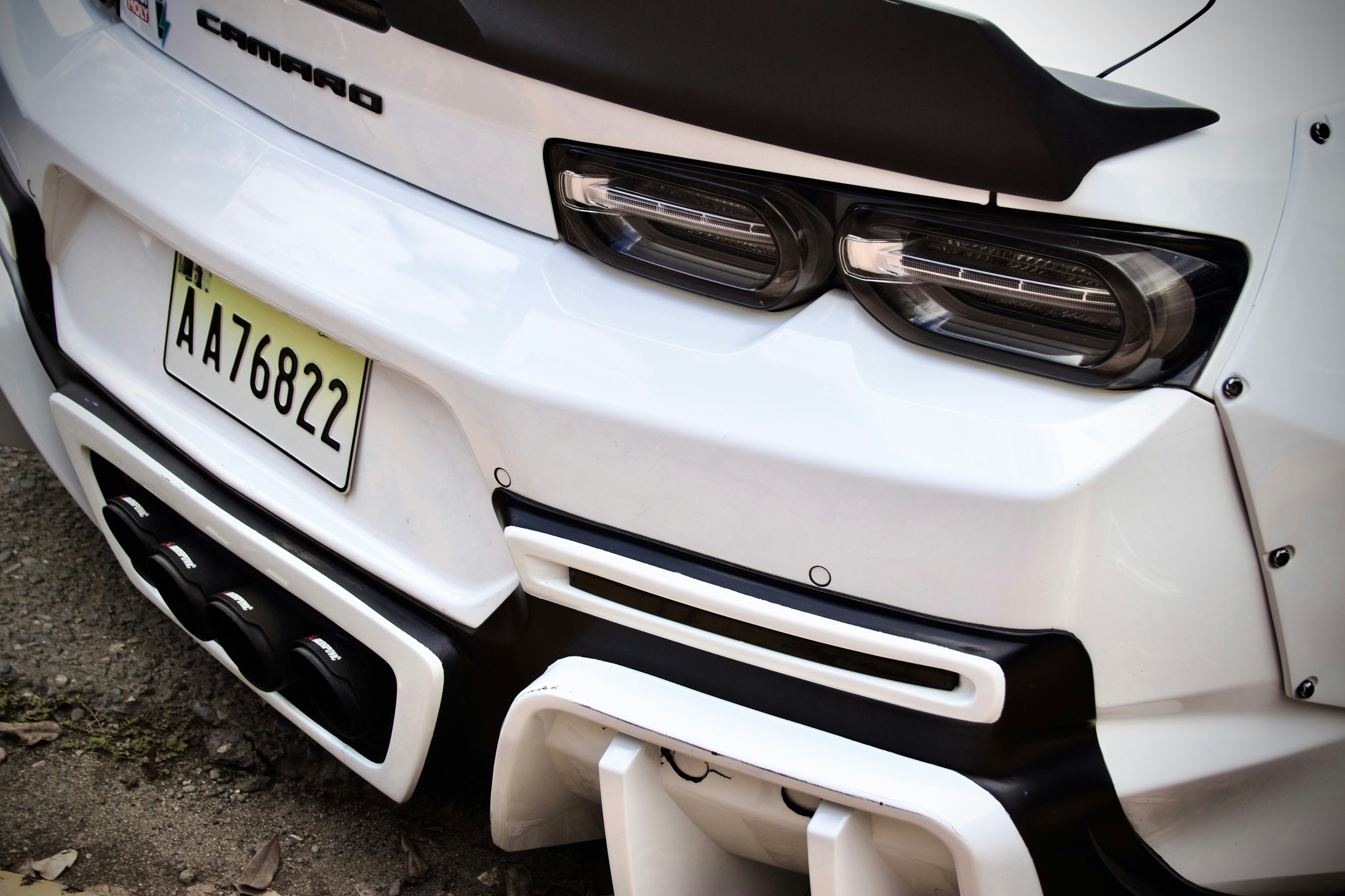 Rear Clarity: The Aggressive Detail of a White Camaro's Taillight and Exhaust