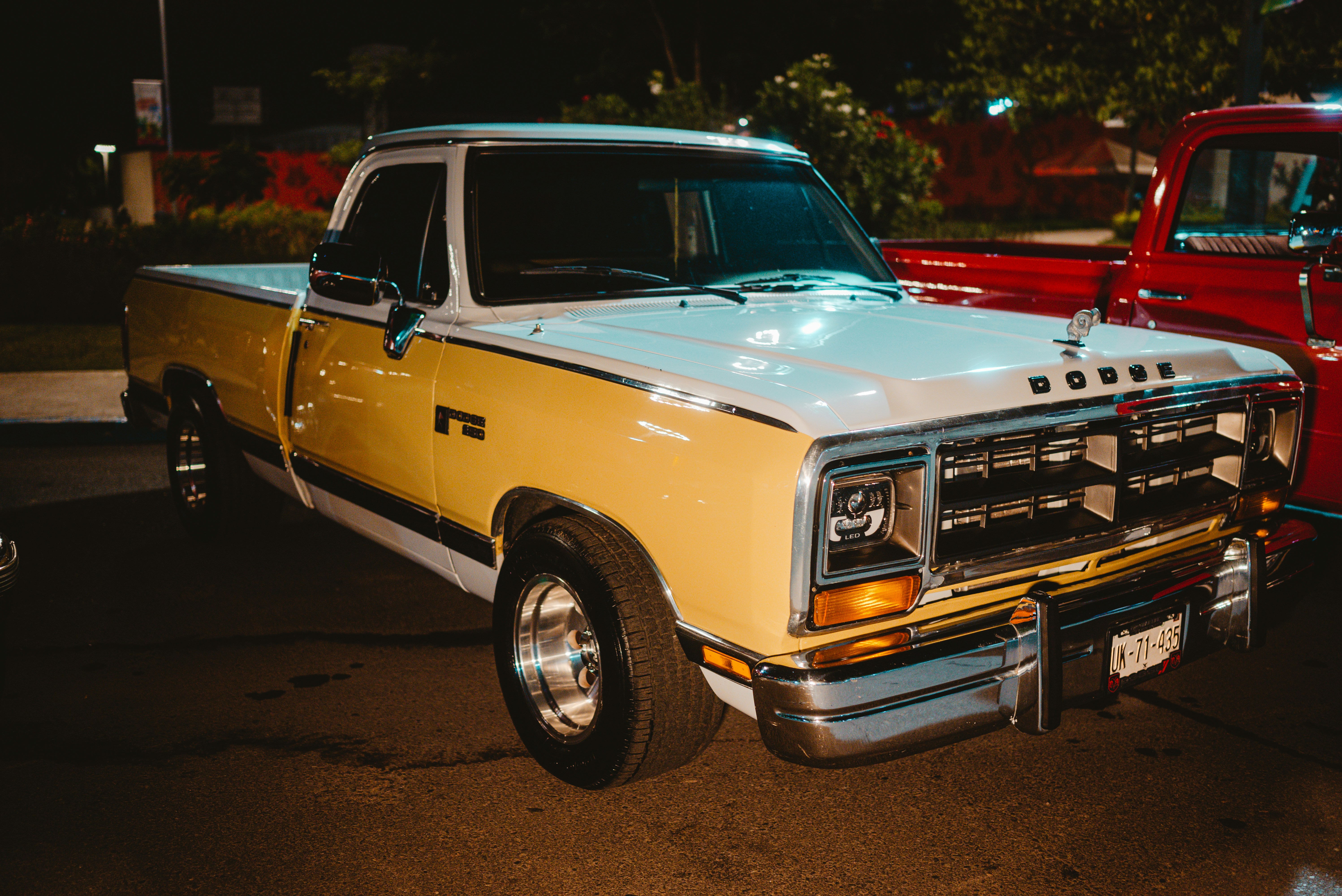 Sunlit vintage Dodge pickup gleams in a night lot
