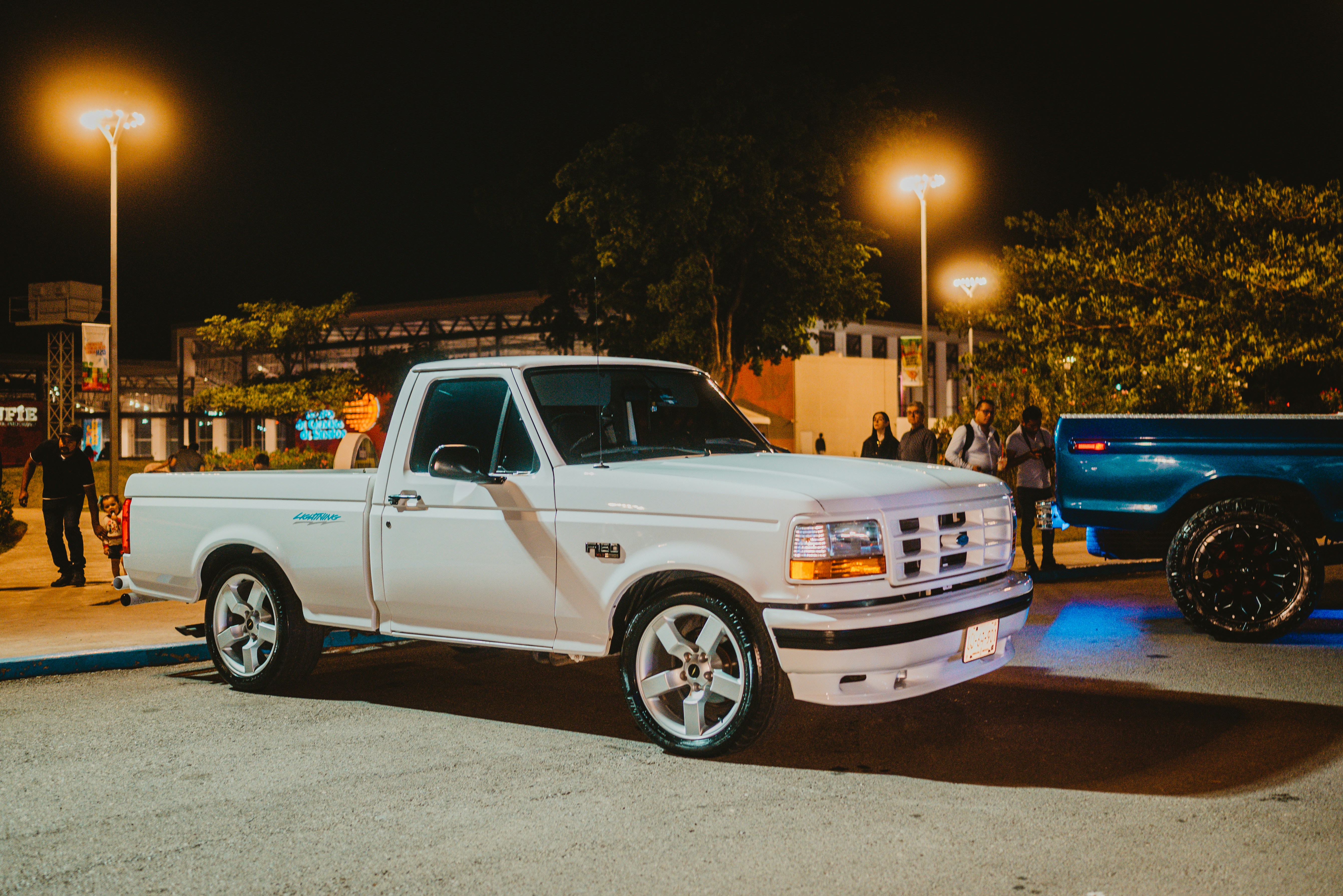 Night meet: White pickup under city glow
