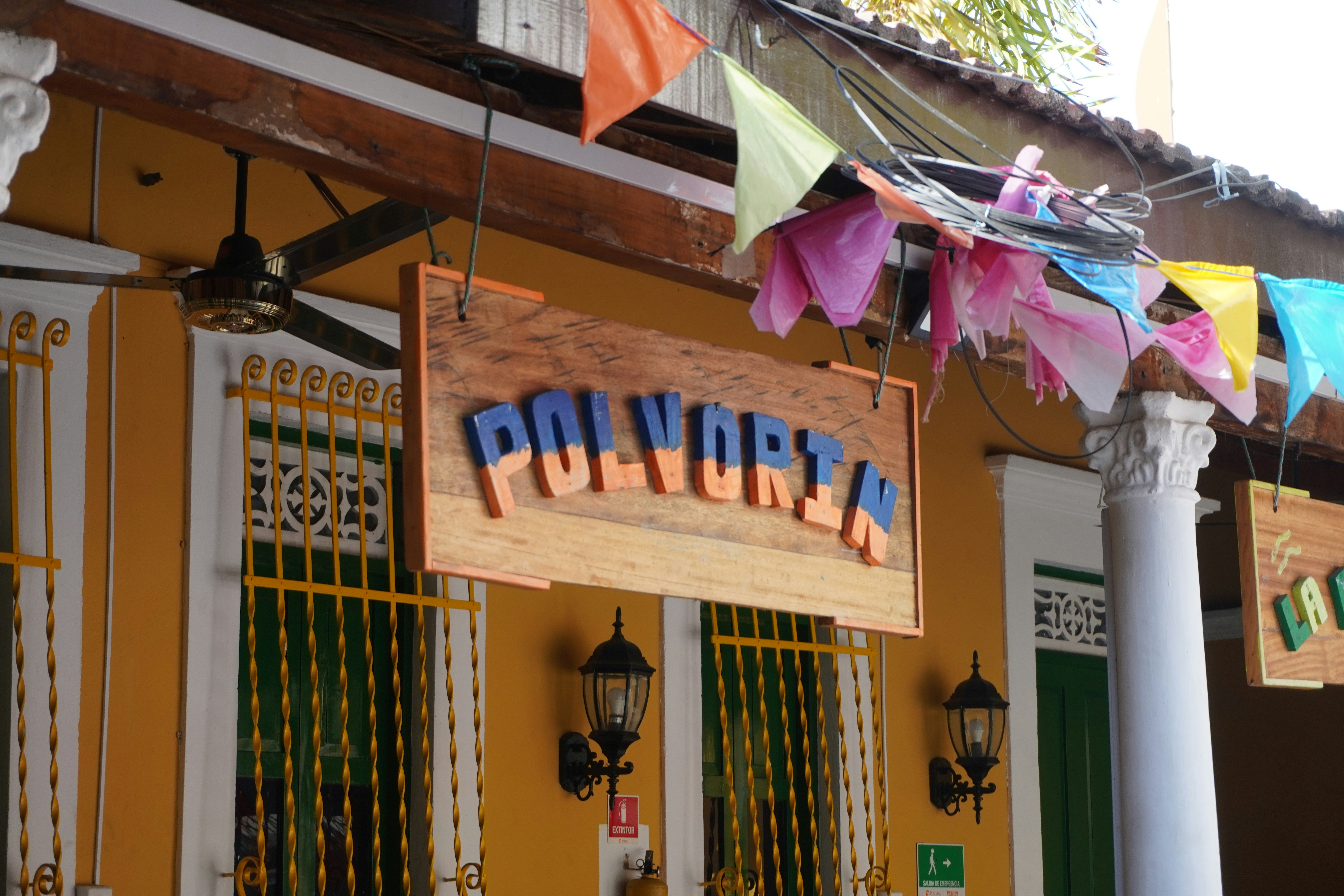 Polvora Chapel: A Vibrant Facade Under Colorful Flags