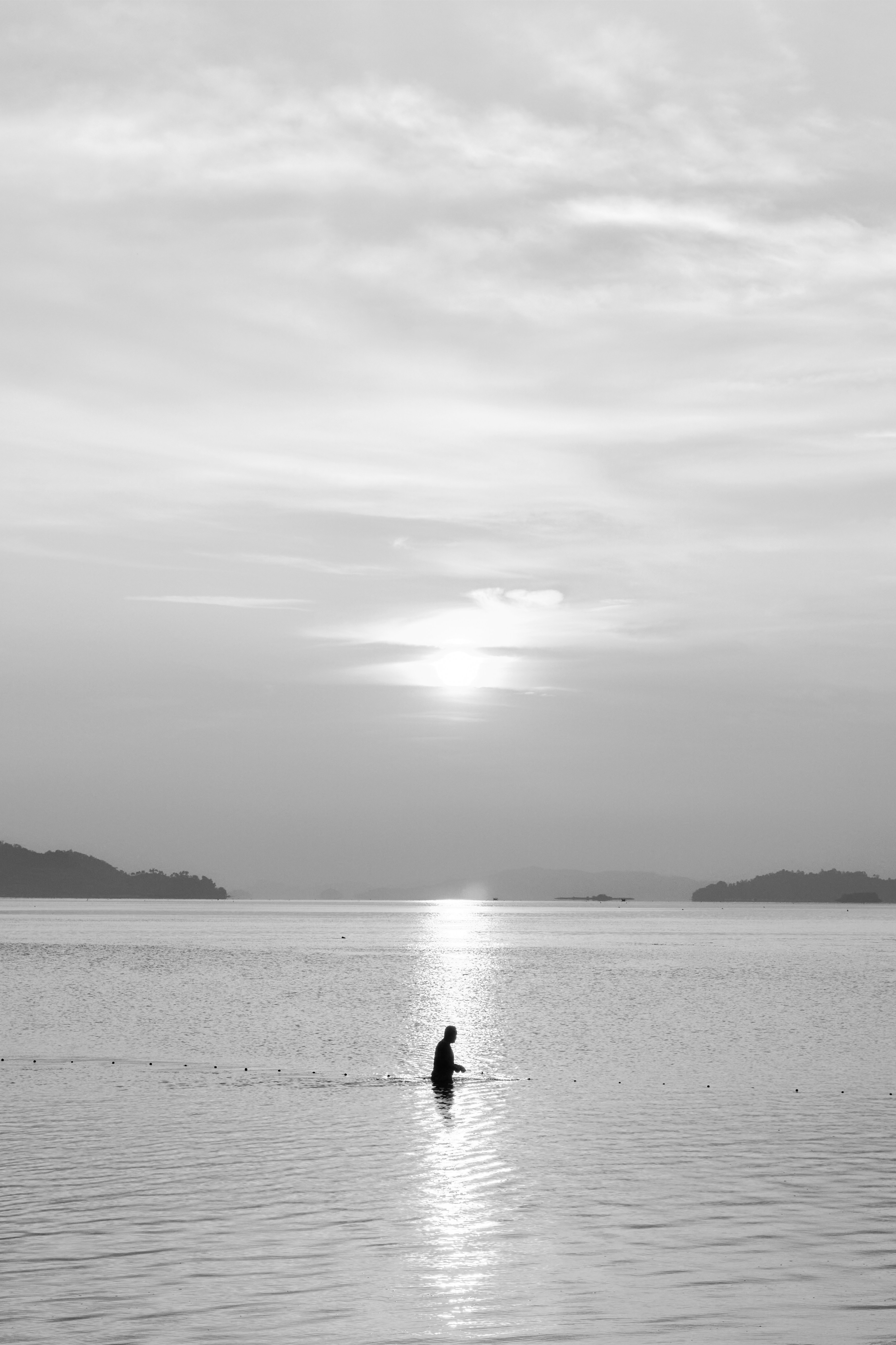 Solitary Fisherman Silhouette at Sunset over Quiet Bays