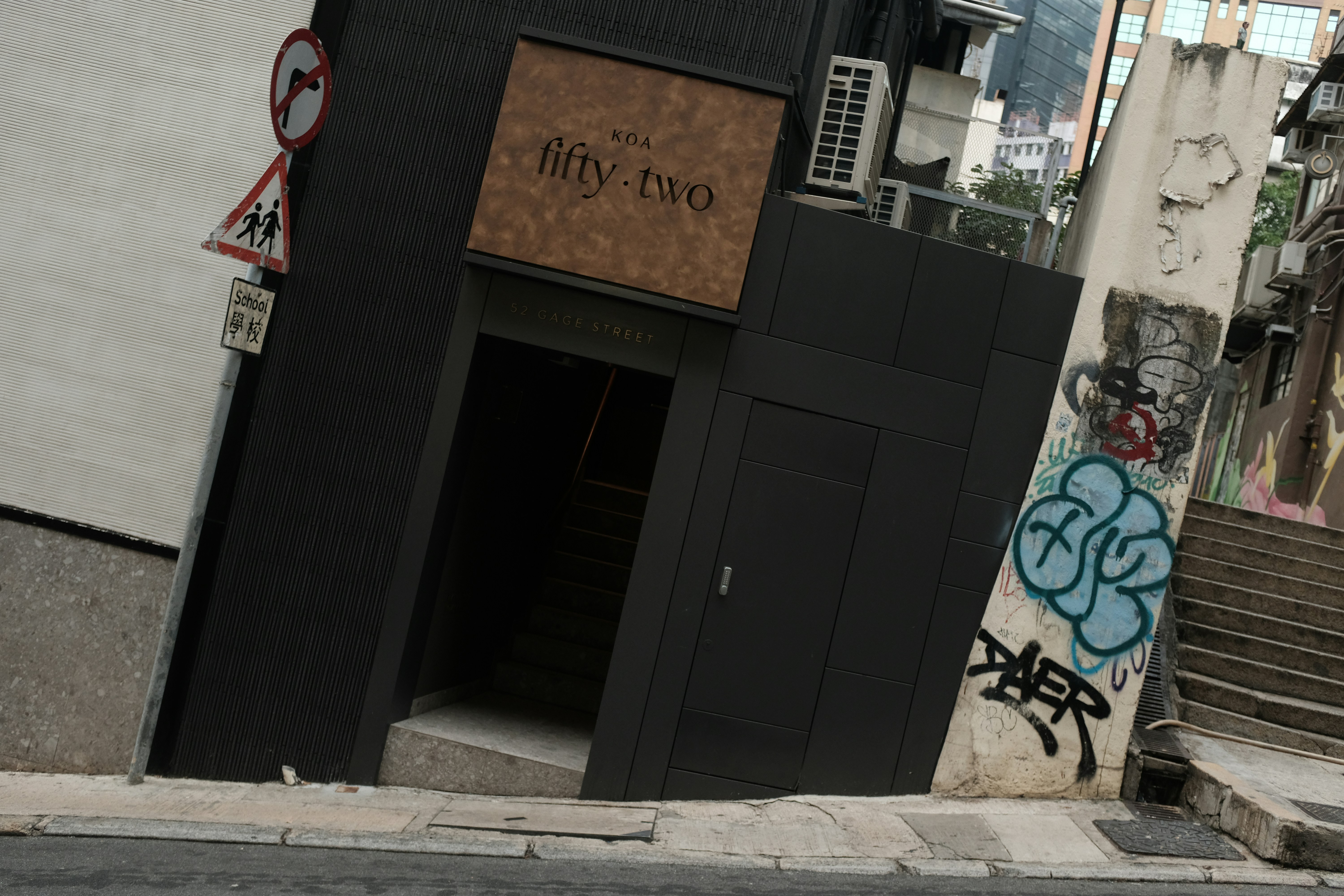 Urban Threshold: The Dark Entry Beneath a Neon Graffitied Stairwell