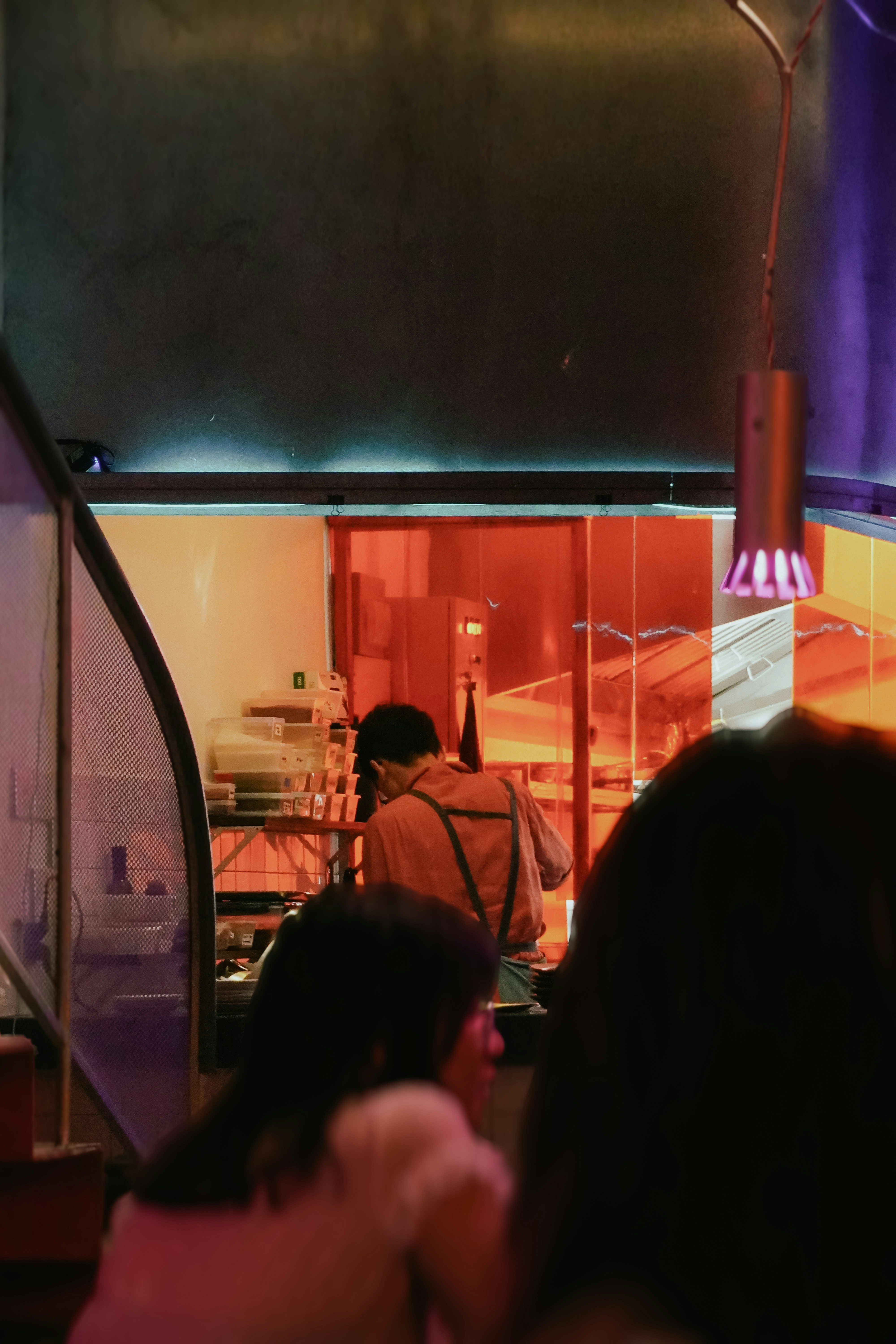Neon-lit Kitchen Through a Café Window