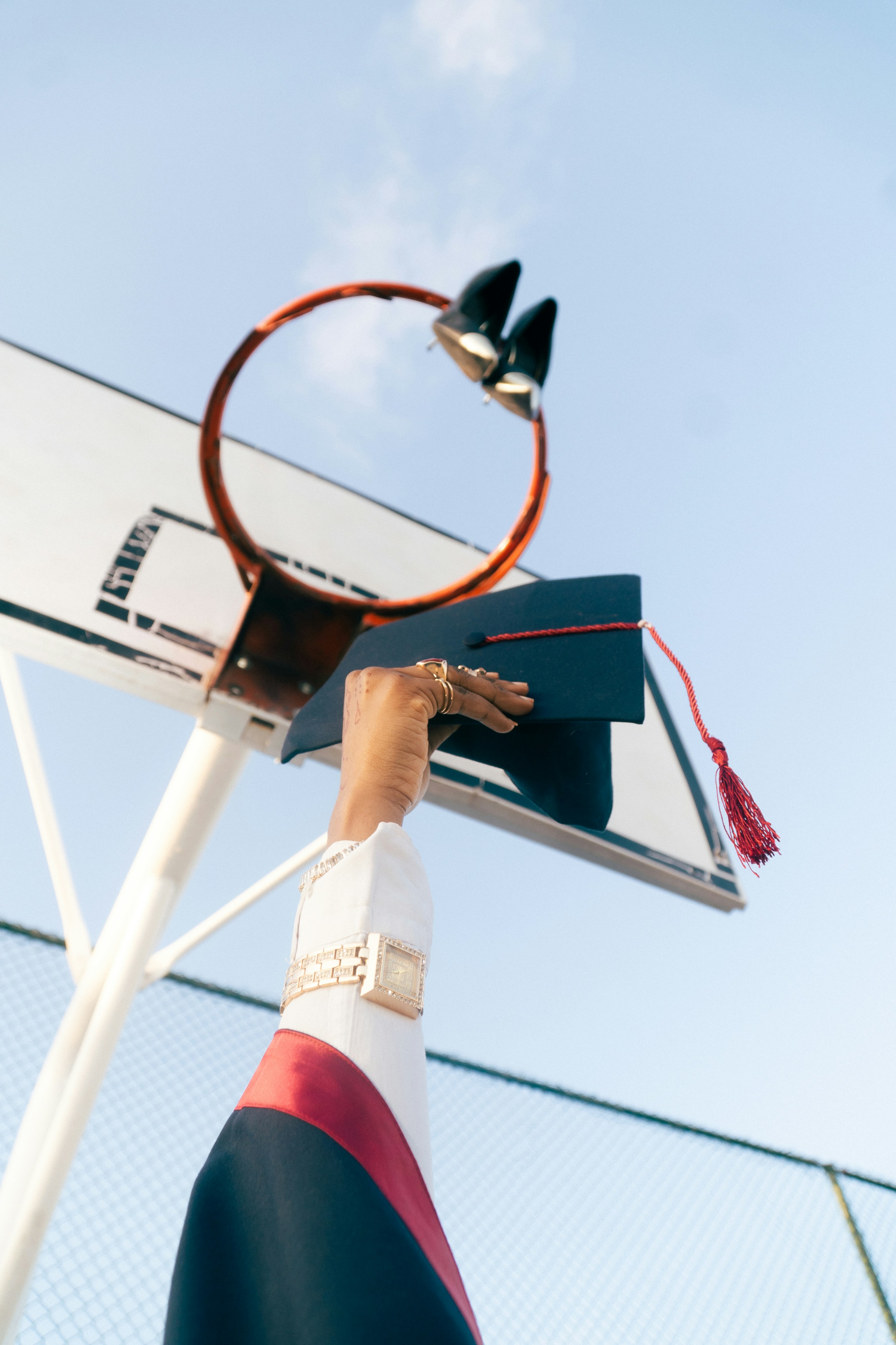 Graduation in the Air: A Hand Reaches for the Tassel under the Hoop