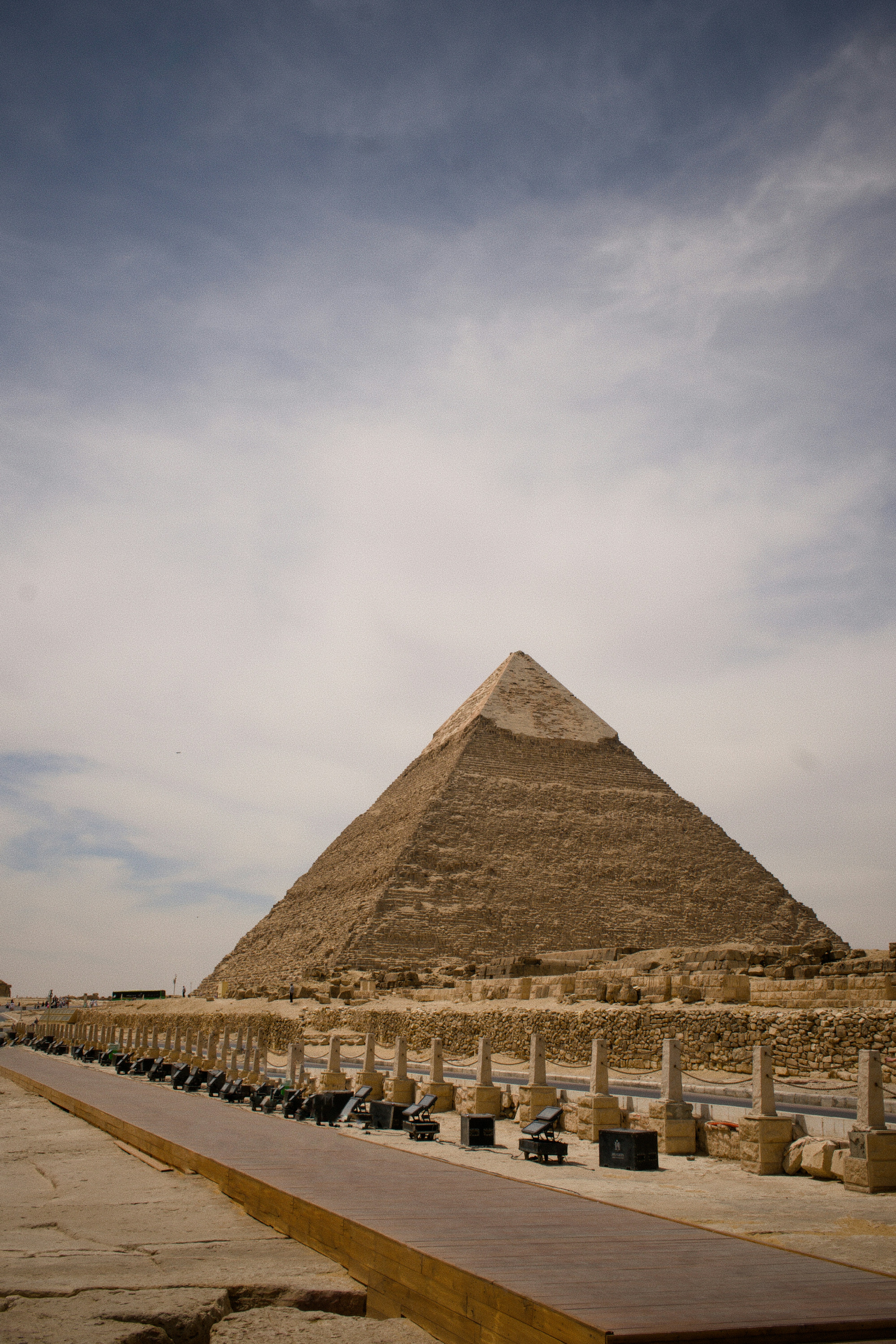 Sunlit Majesty: The Great Pyramid Rising Over a Desert Footpath