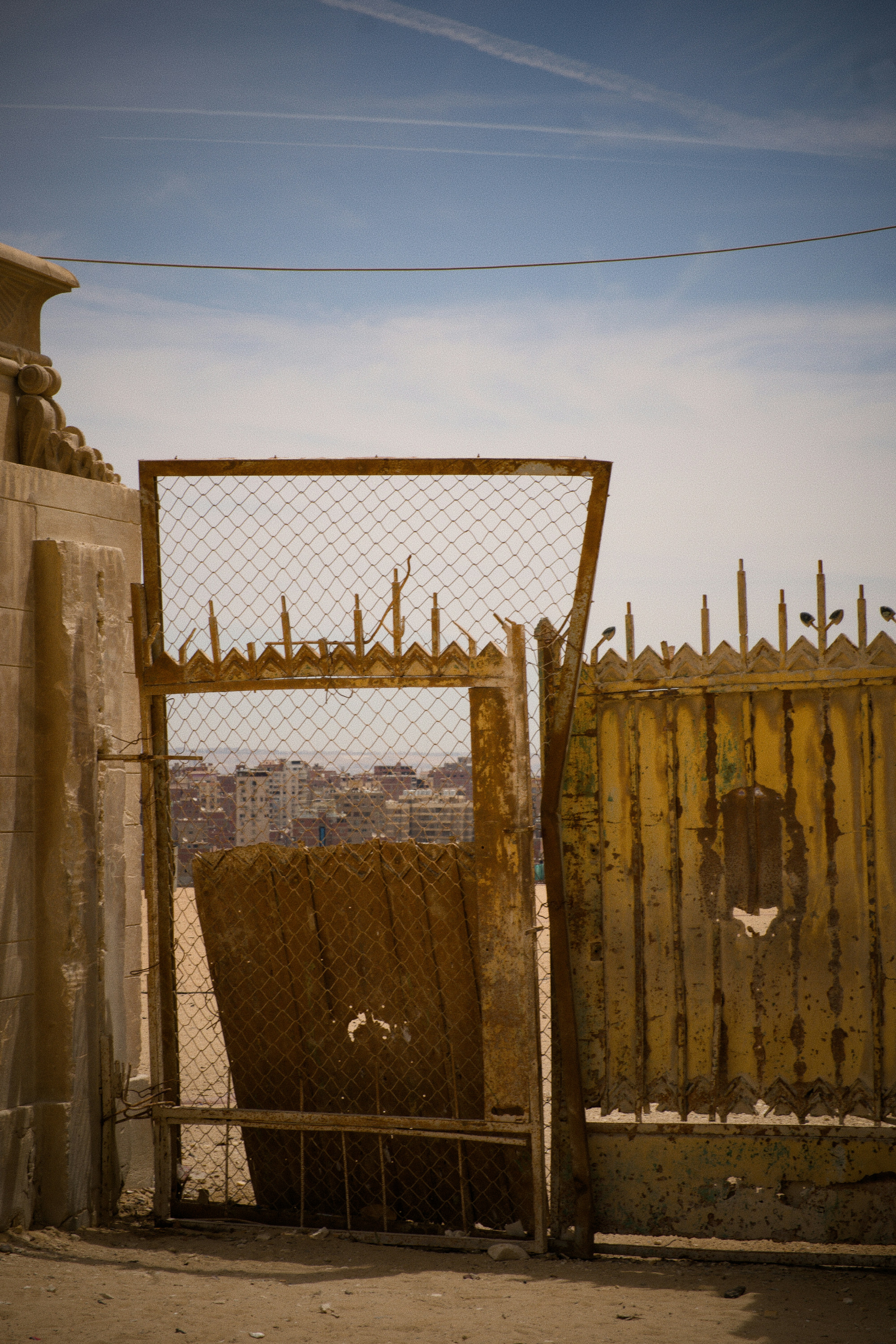 Rusted Gate to a Distant Cityscape